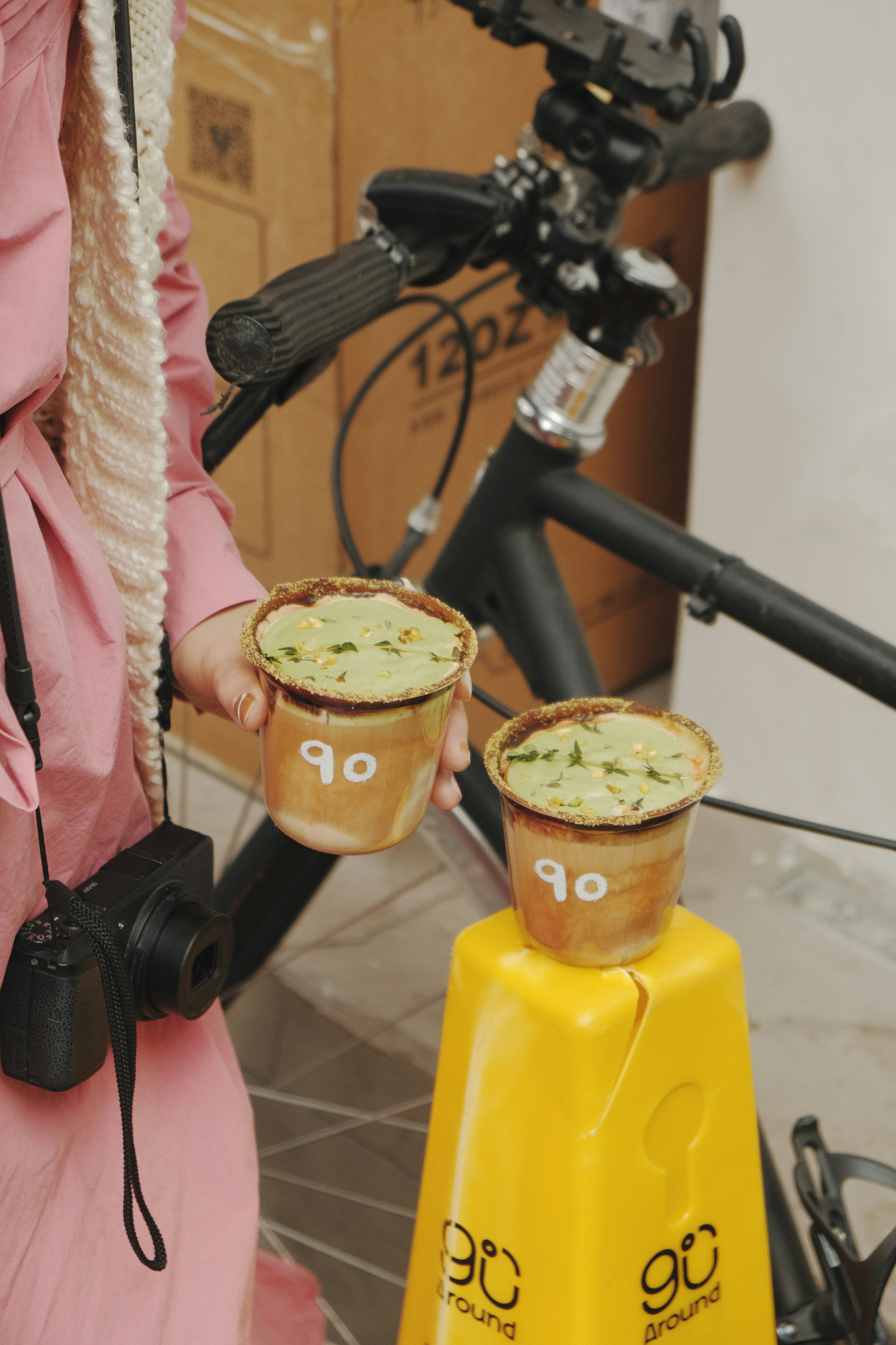 Cafe Cups on a Yellow Stand Beside a Bicycle