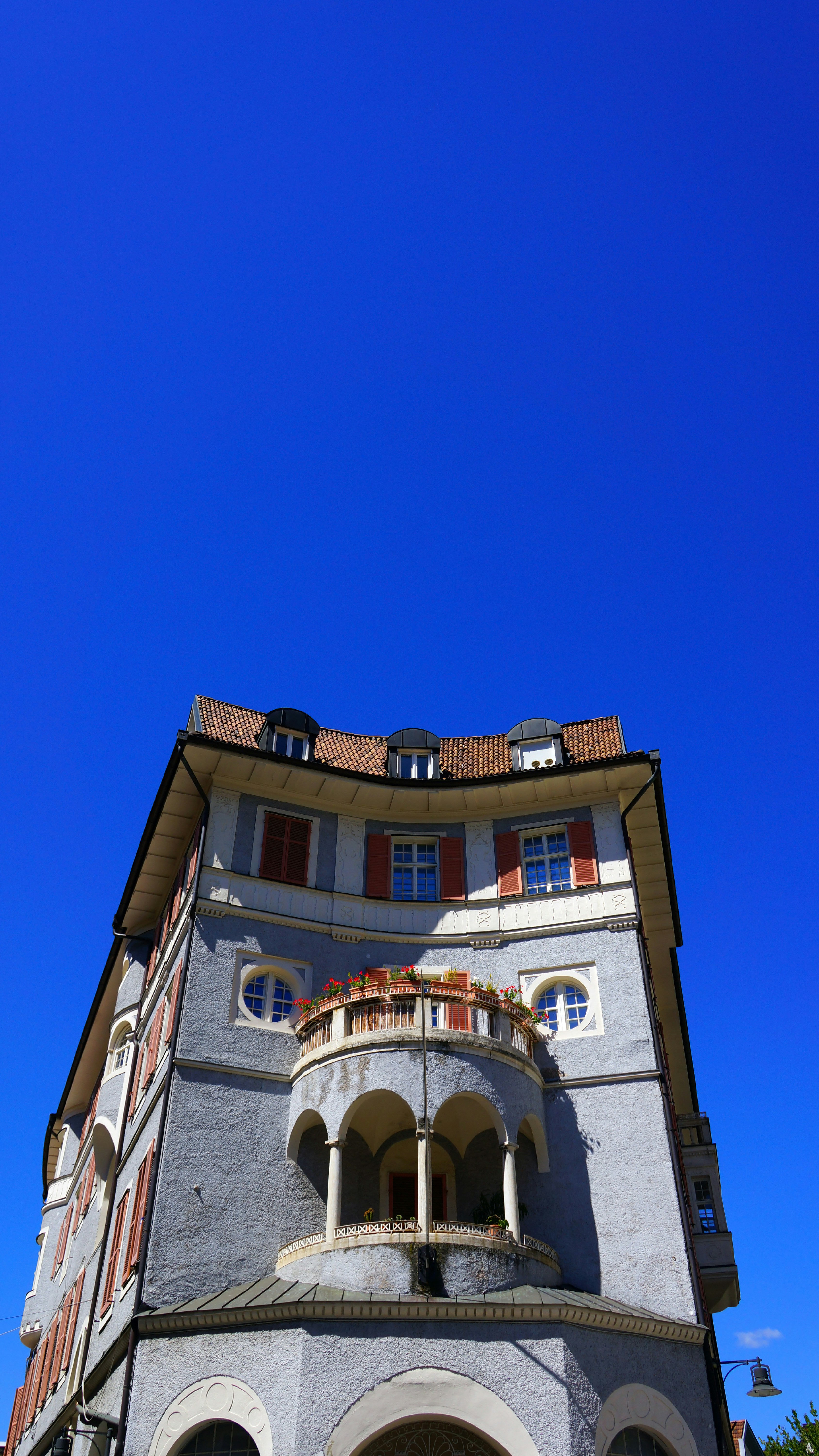 Cerulean Sky Framing a Curved Veranda on a European Facade