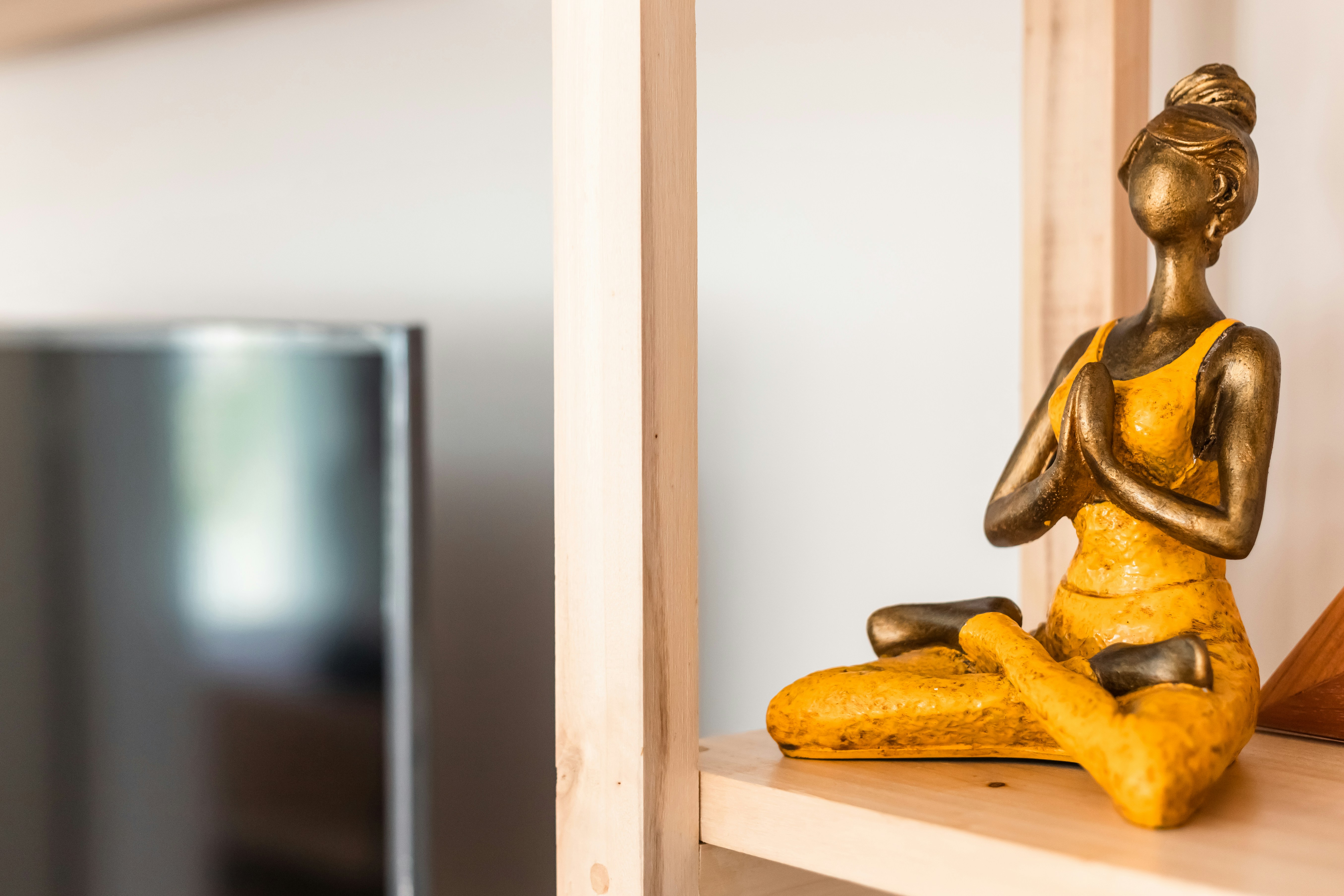 Golden Quietude: A Meditative Figurine Anchored on a Shelf