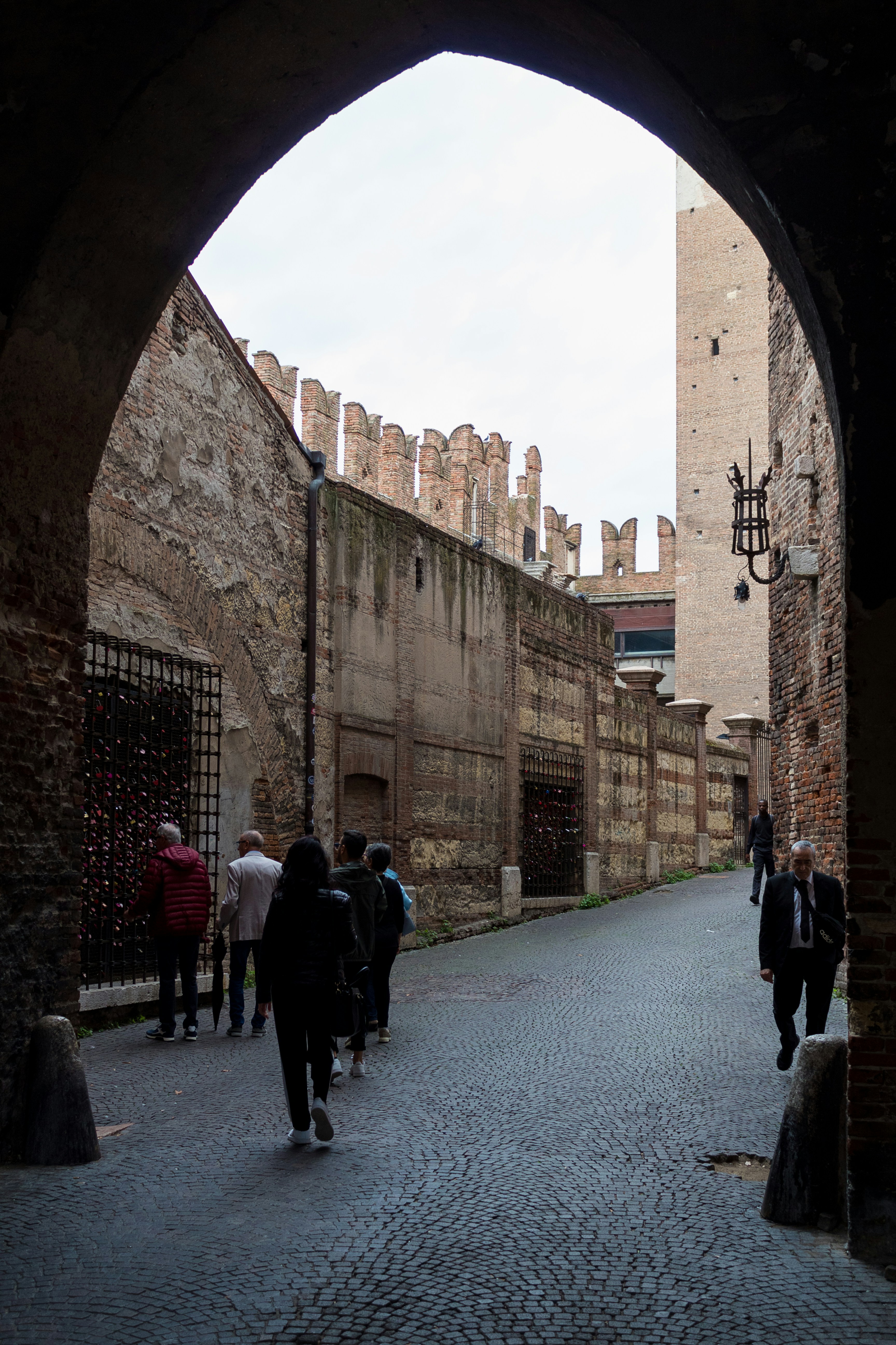 People walking under a stone archway photo – Free People Image on Unsplash