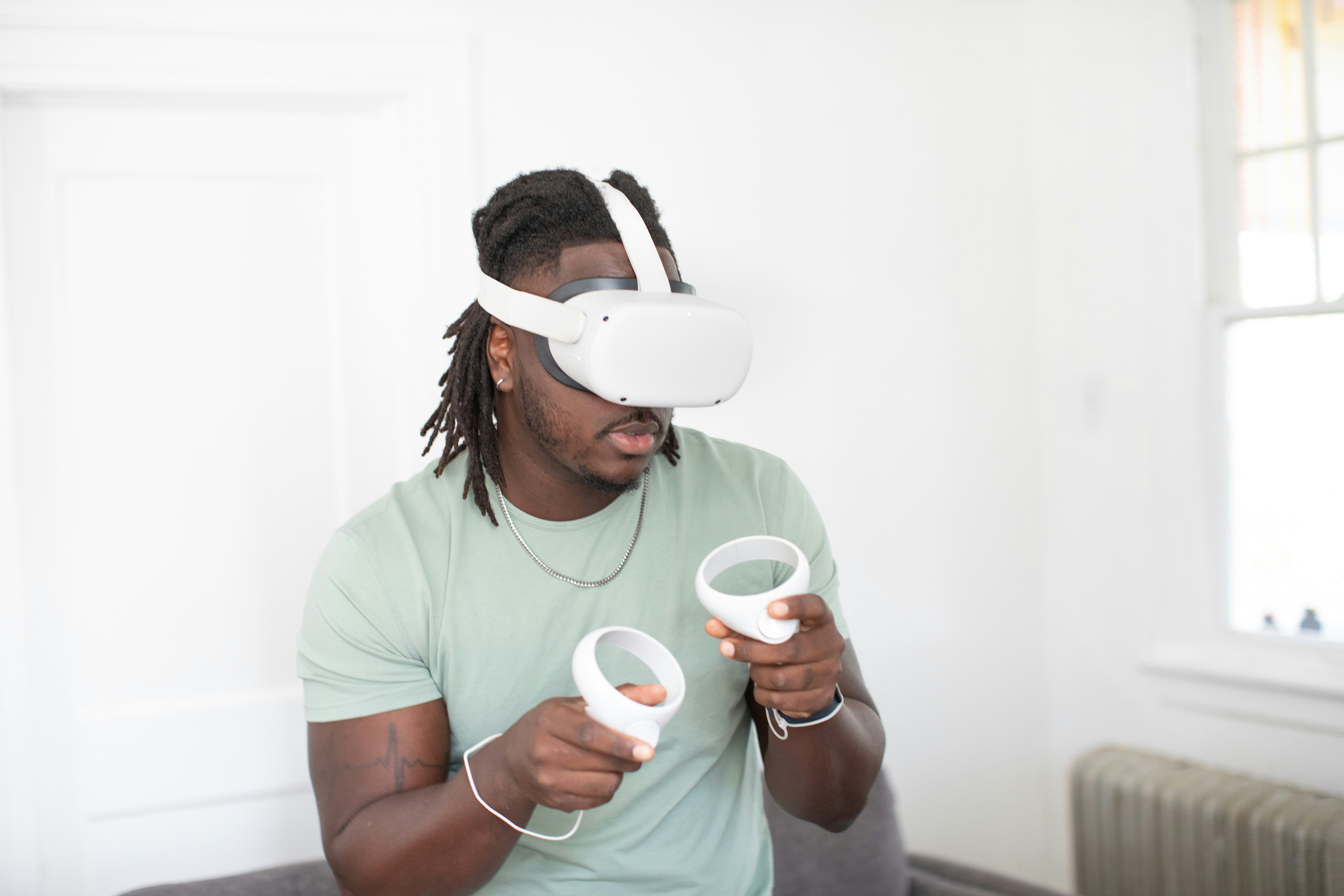A person wearing a vr headset holding a cup and a game controller photo ...