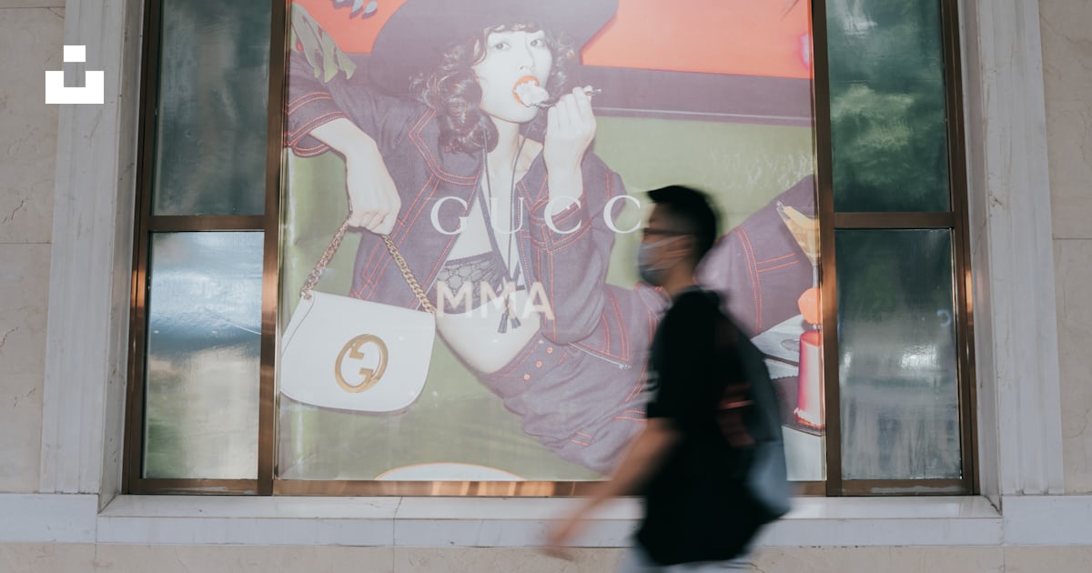 큰 포스터 옆을 걷는 남자 사진 Unsplash의 무료 트랑티엔플라자 이미지