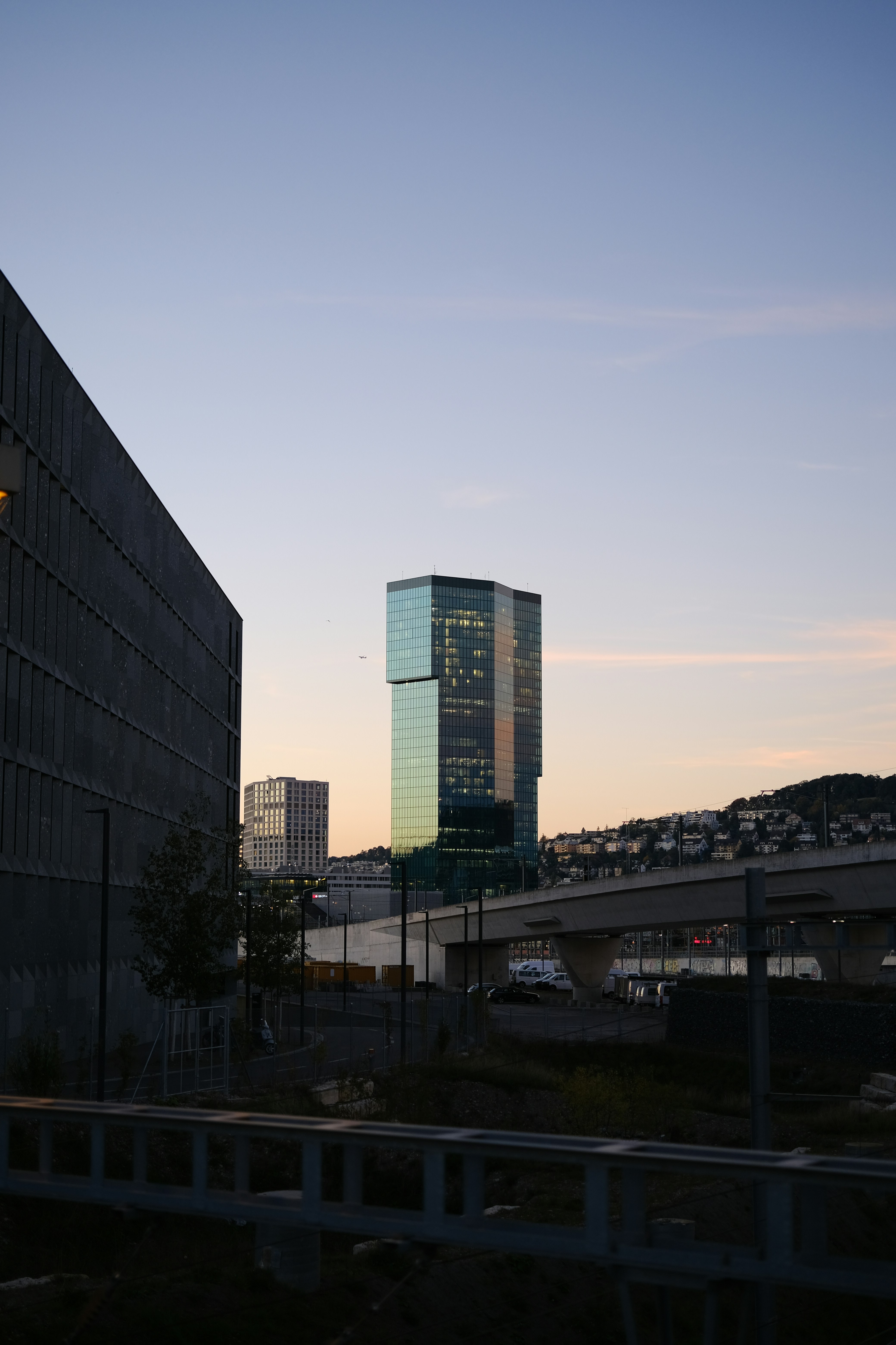 Un edificio alto con un puente y una carretera con árboles y un puente foto – Imagen de Zúrich ...