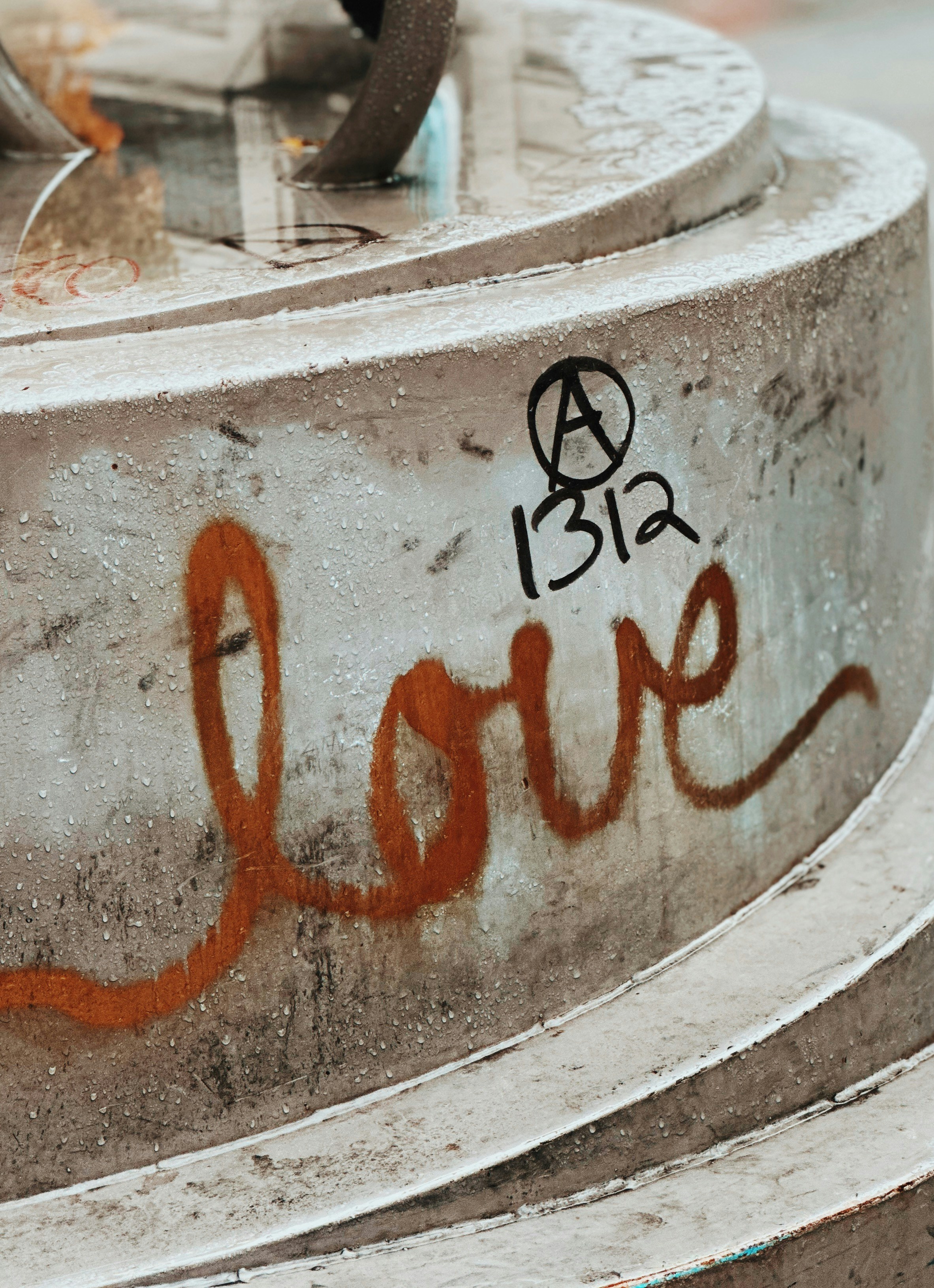 Love on a Weathered Post: Orange Script Curves Across Cold Metal