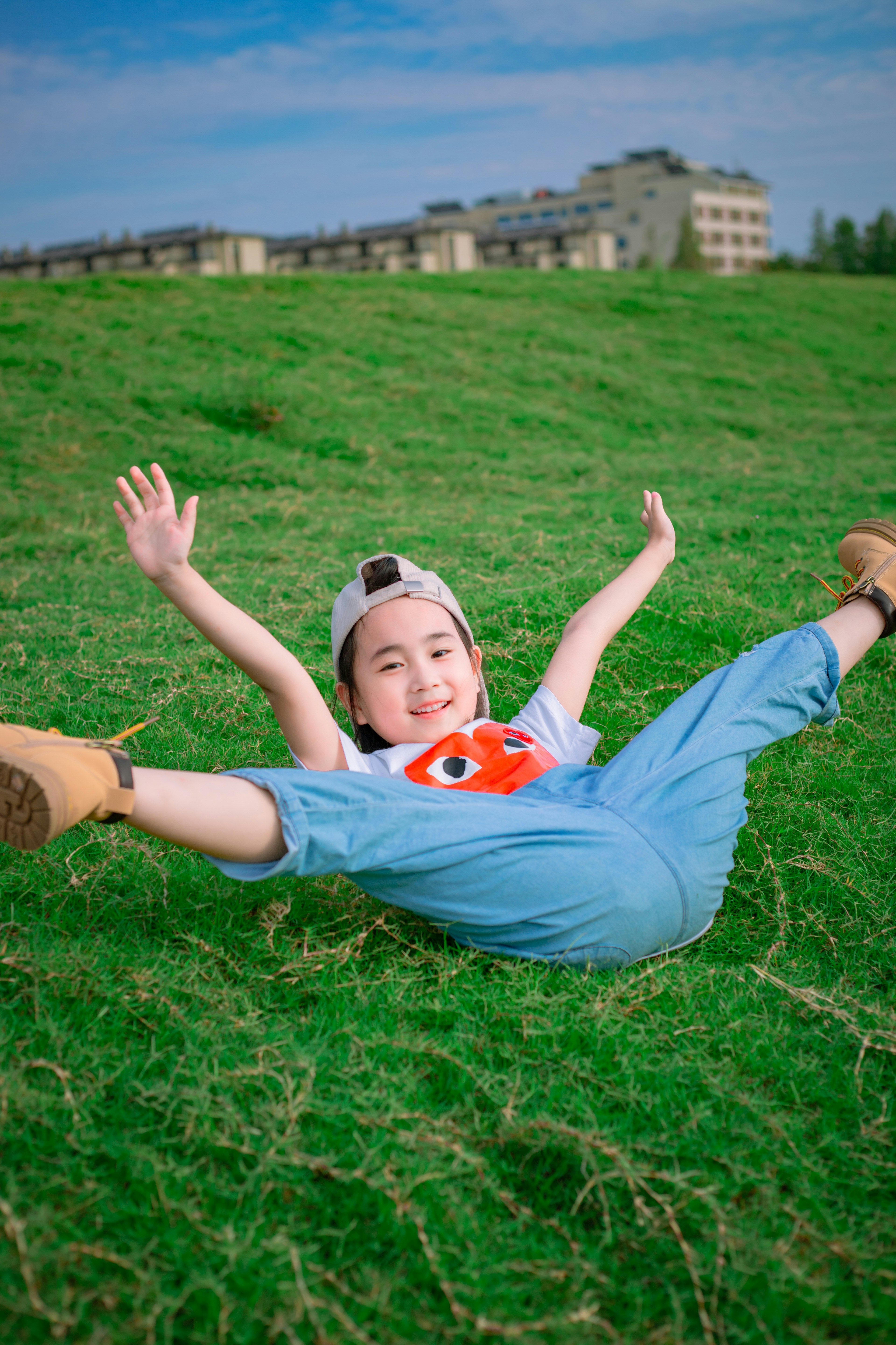 Joyful tumble on the hill: kid in motion with outstretched arms