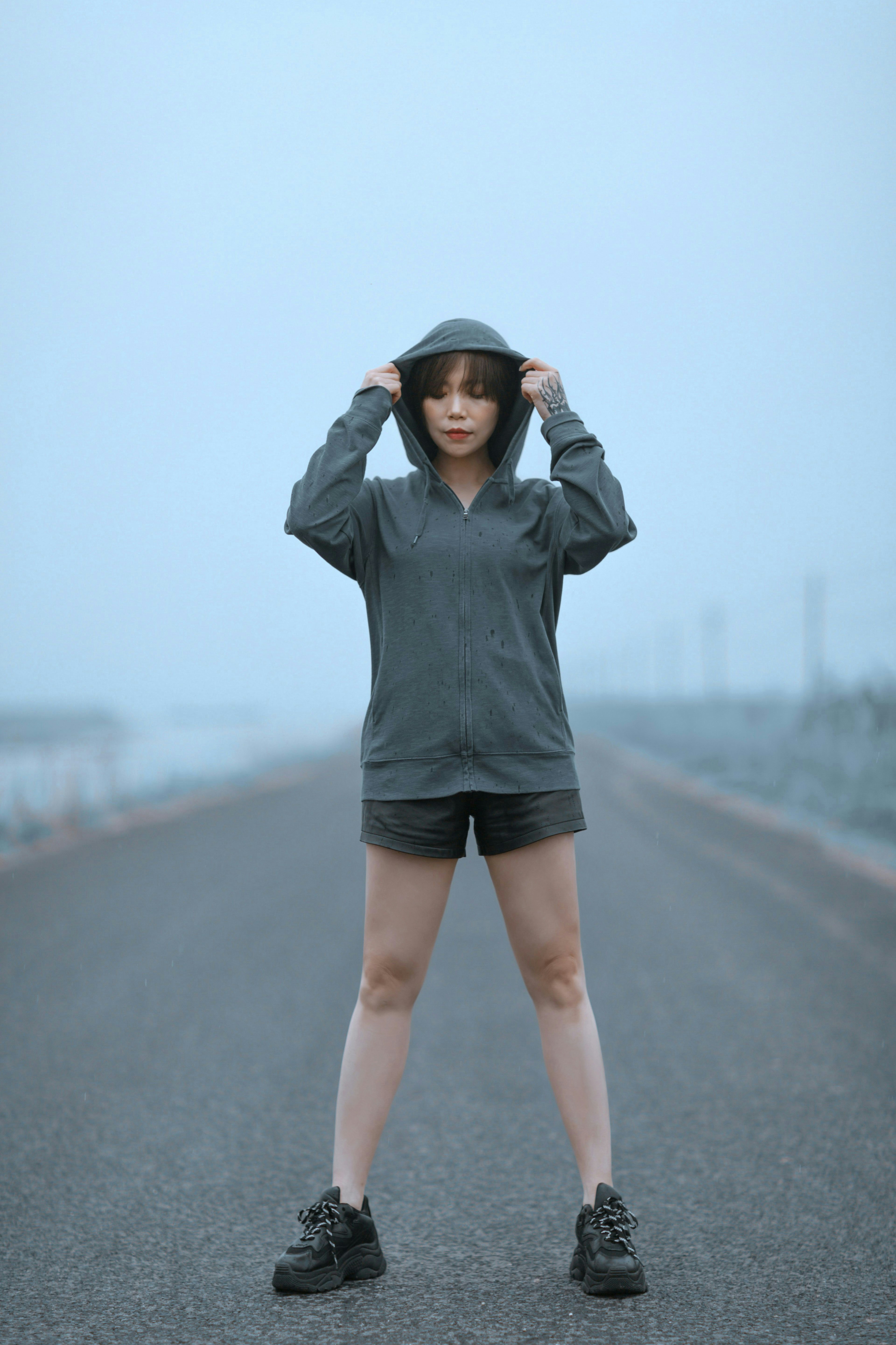 Hooded Stance on a Misty Coastal Road