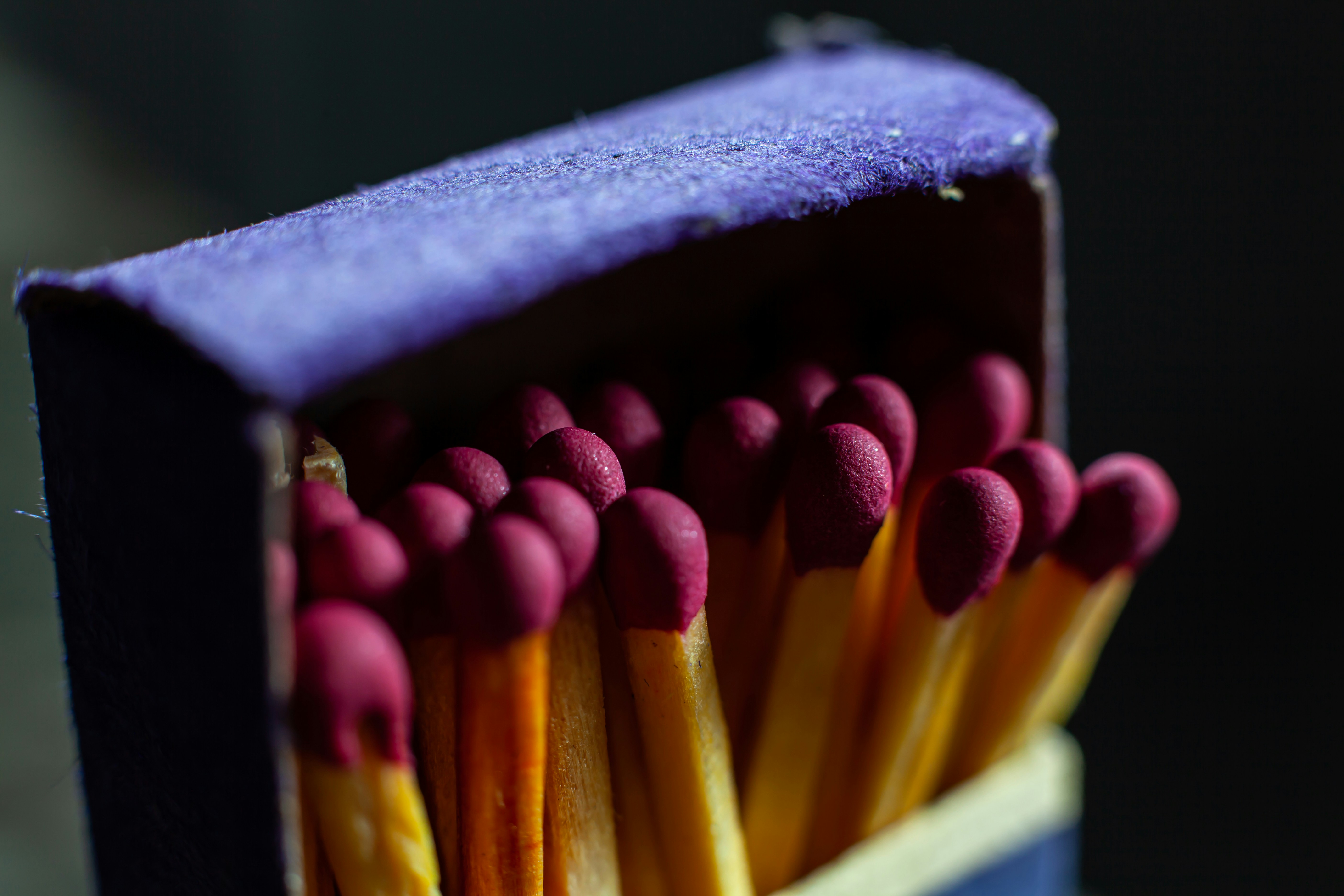 Macro close-up: violet-tipped matches in a blue box