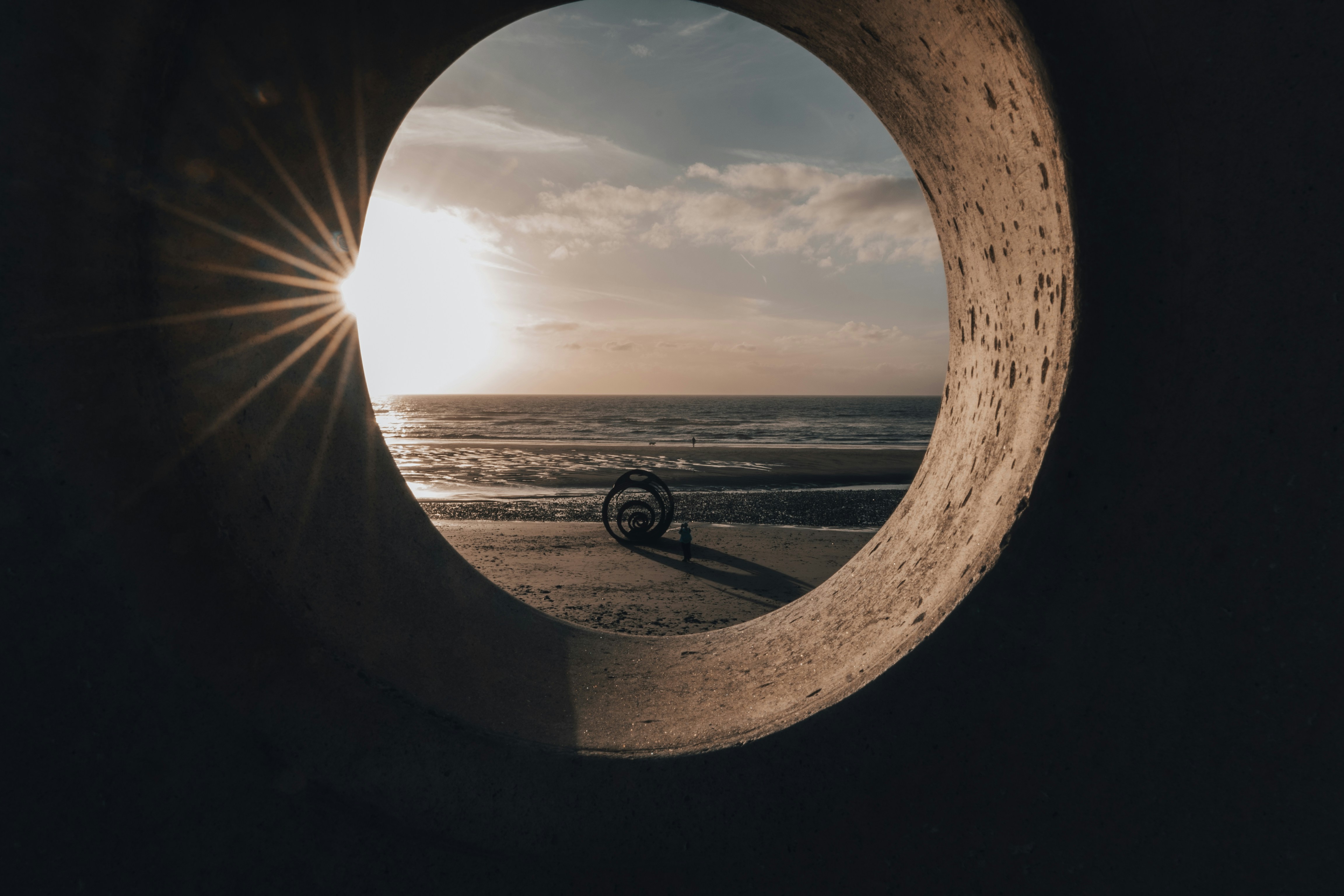 A view of the ocean through a hole in a stone wall photo – Free People ...