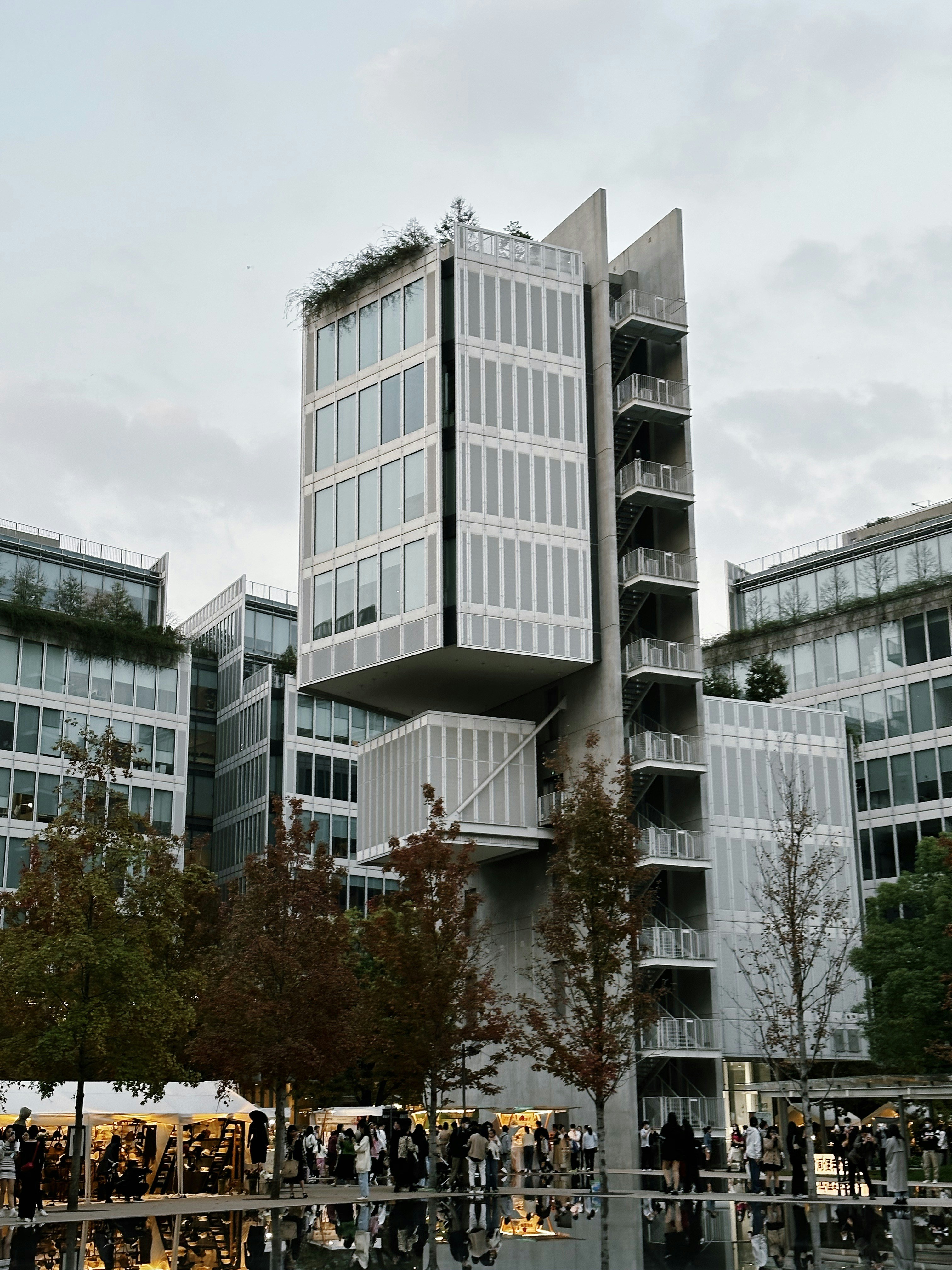 Floating Glass Block: A Skyward Sculpture Over a Lively Plaza