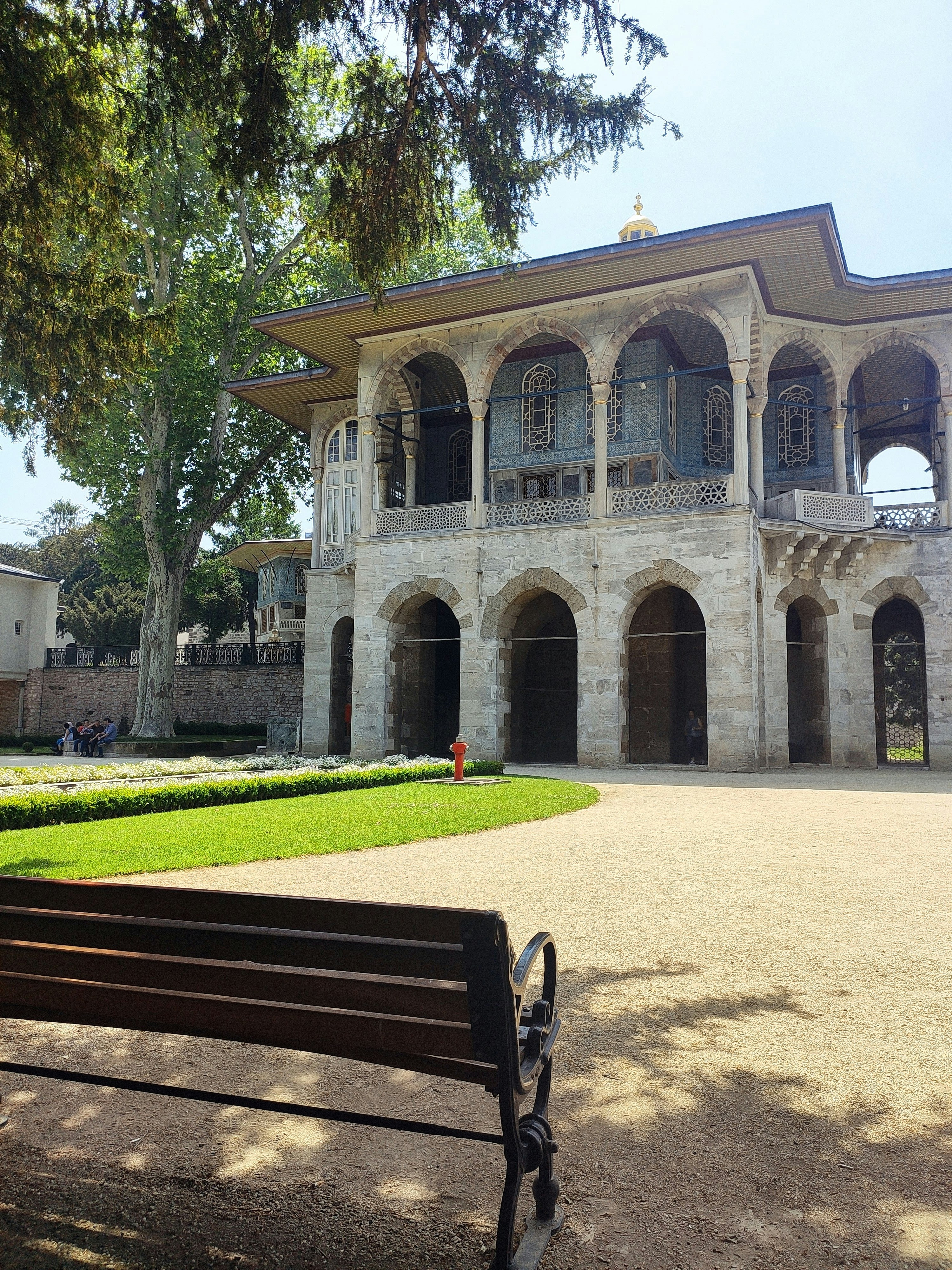 Historic pavilion bathed in afternoon light framed by a lone bench