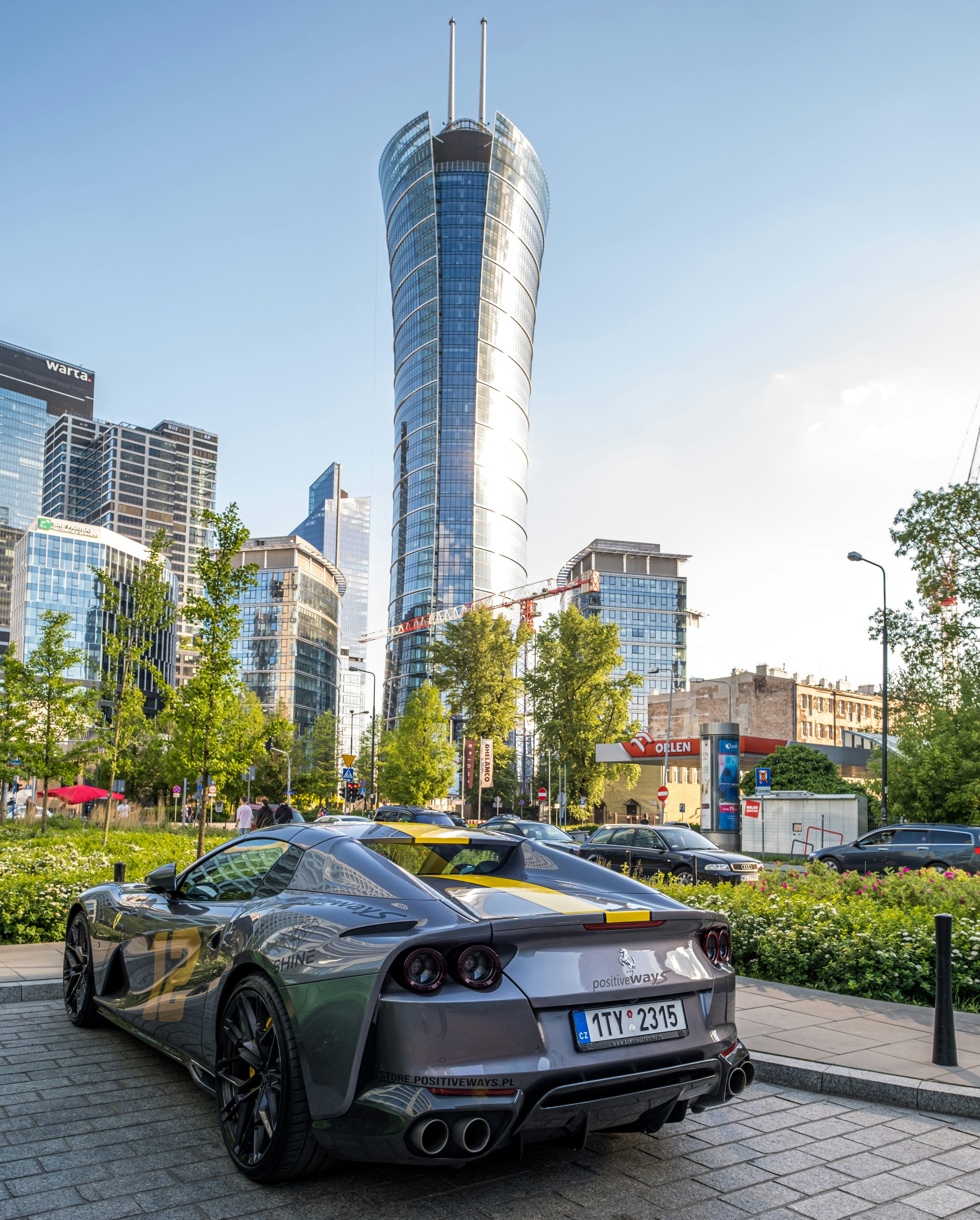 Gray Ferrari at the Threshold of a Futuristic Skyline