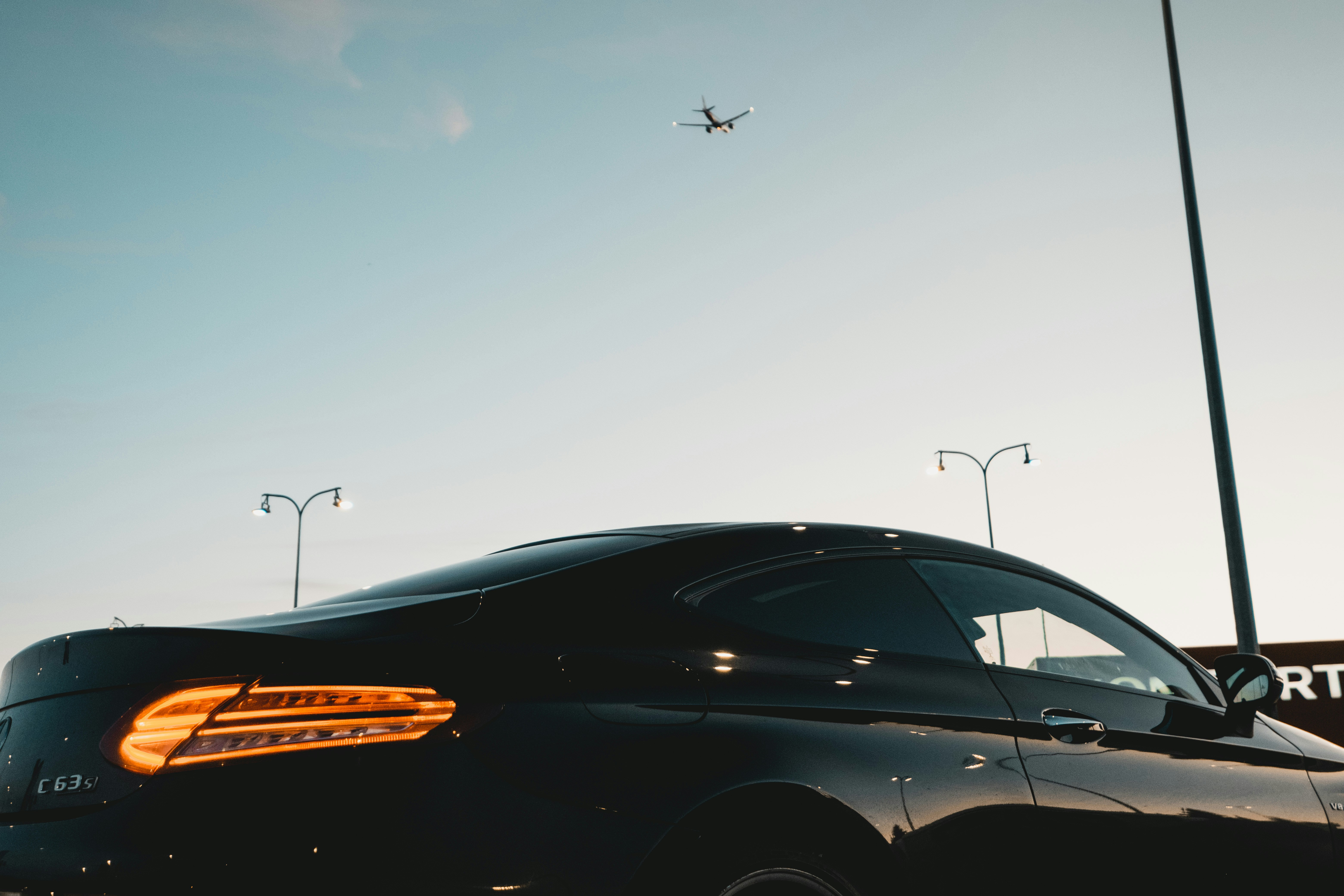 A plane flying over a car photo – Free Plane Image on Unsplash