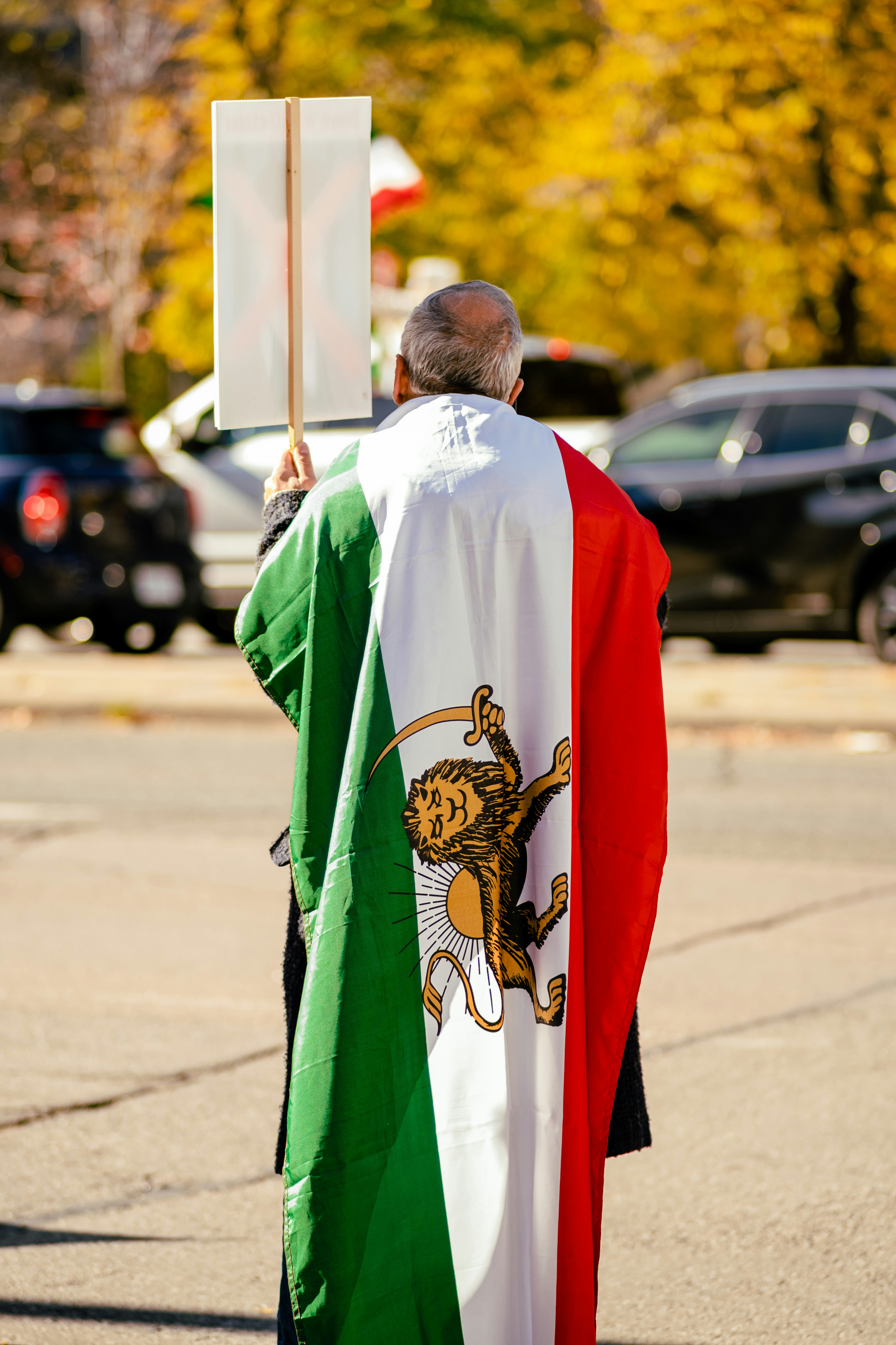 A person in a green robe holding a flag photo – Free Toronto Image on ...