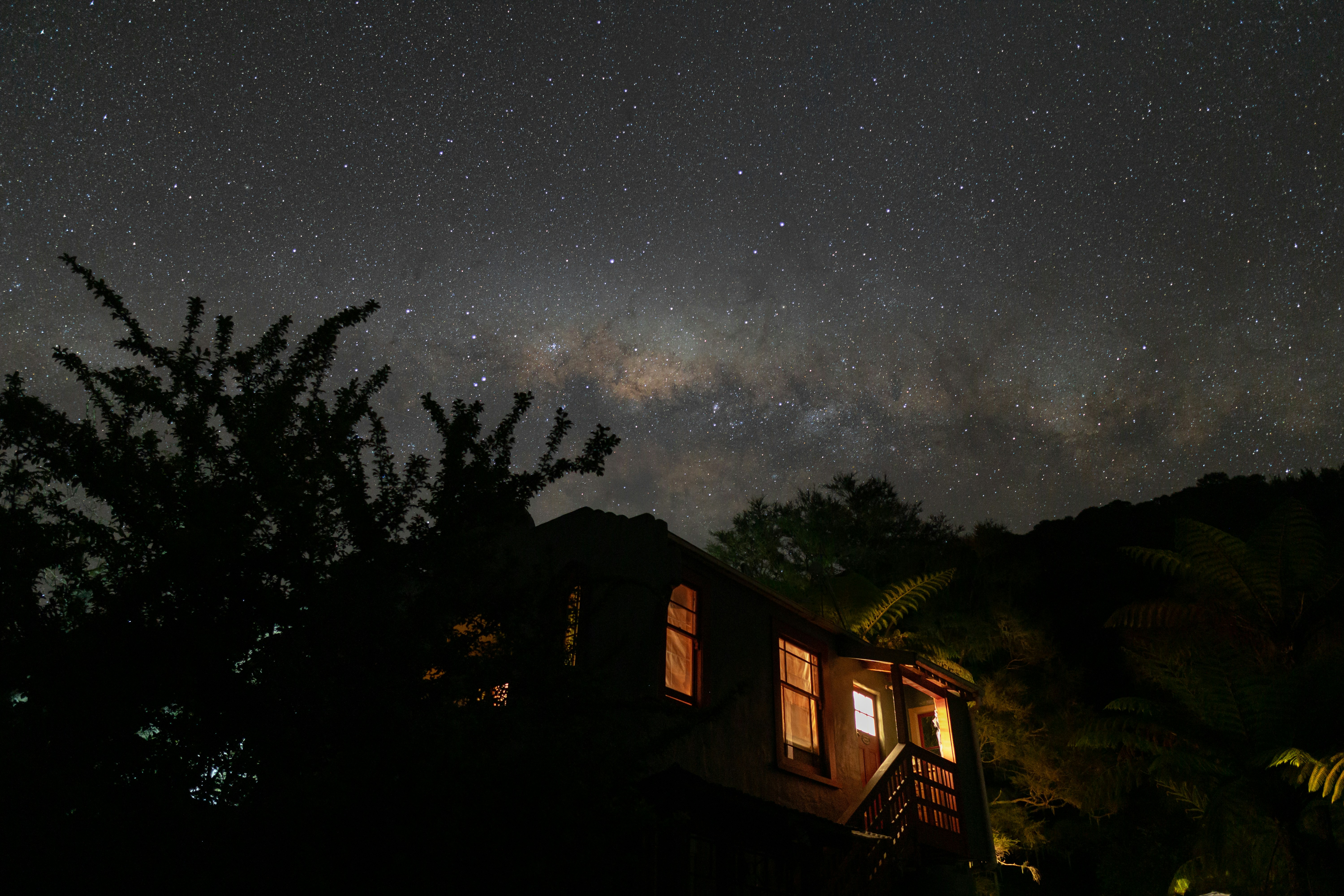 Milky Way Over a Lantern-Lit Cottage