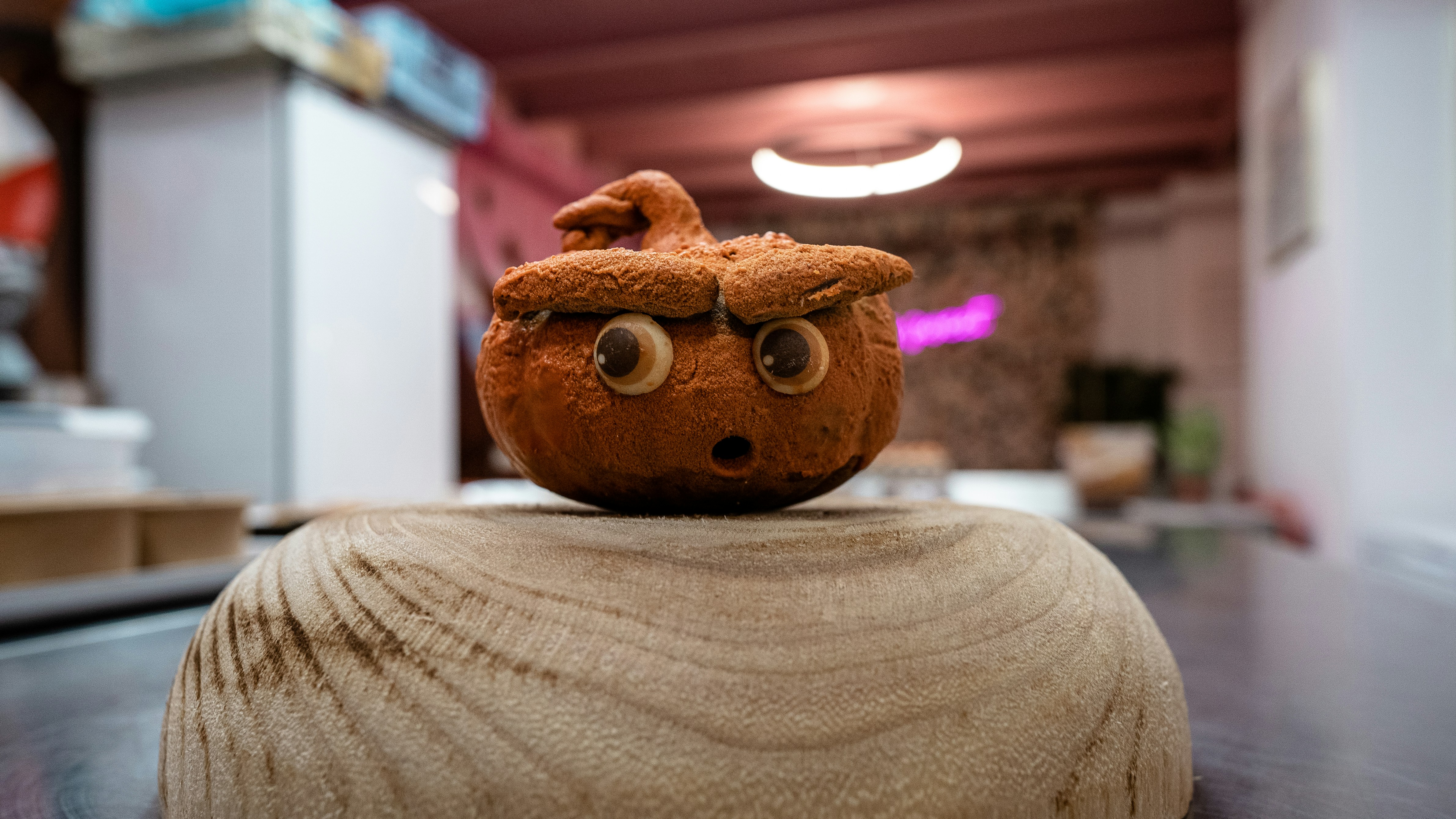 Tiny Plush Pumpkin on a Carved Wooden Plinth: A Warm, Quirky Studio Moment