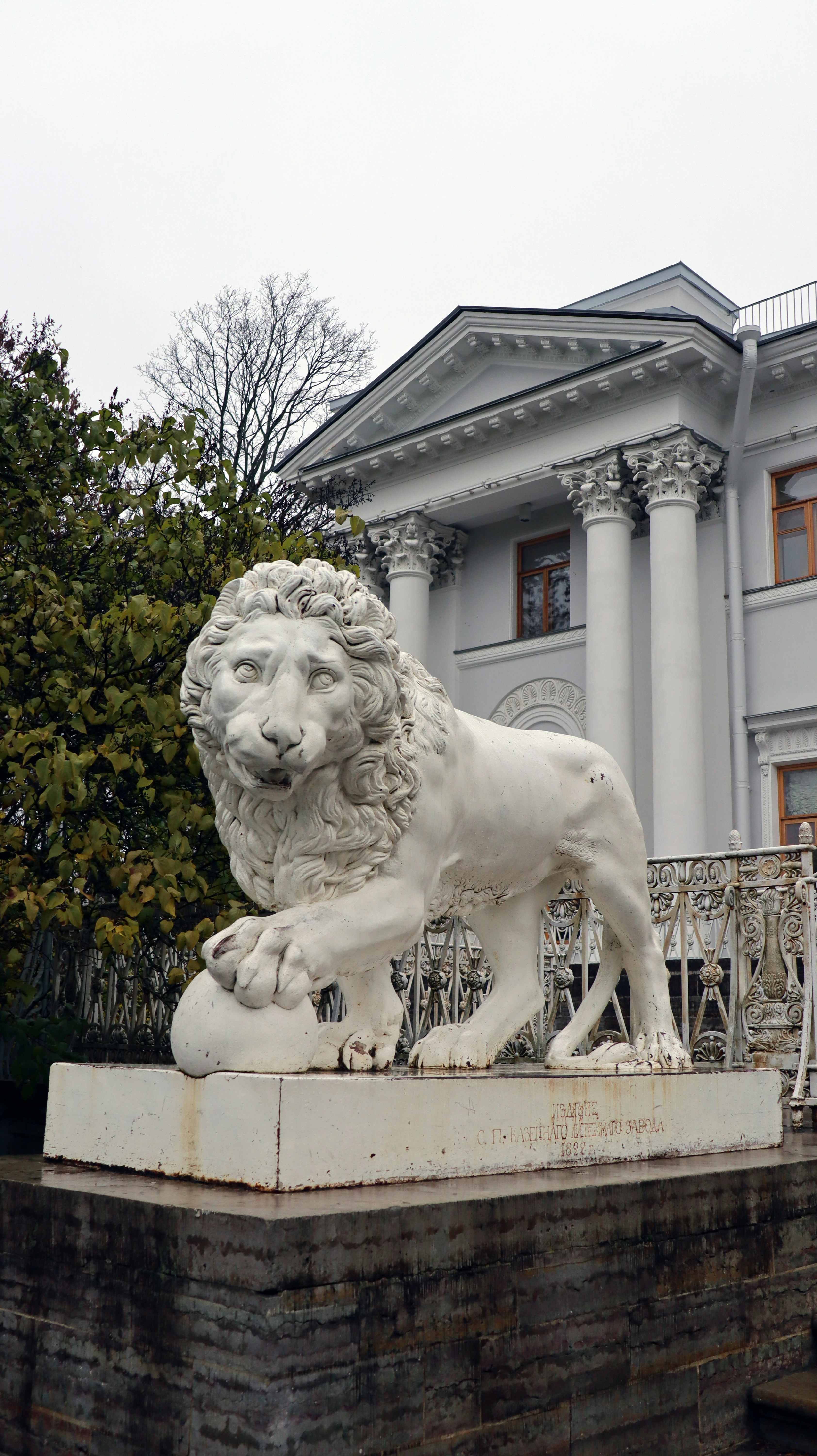 A statue of a lion on a brick wall in front of a building photo – Free ...