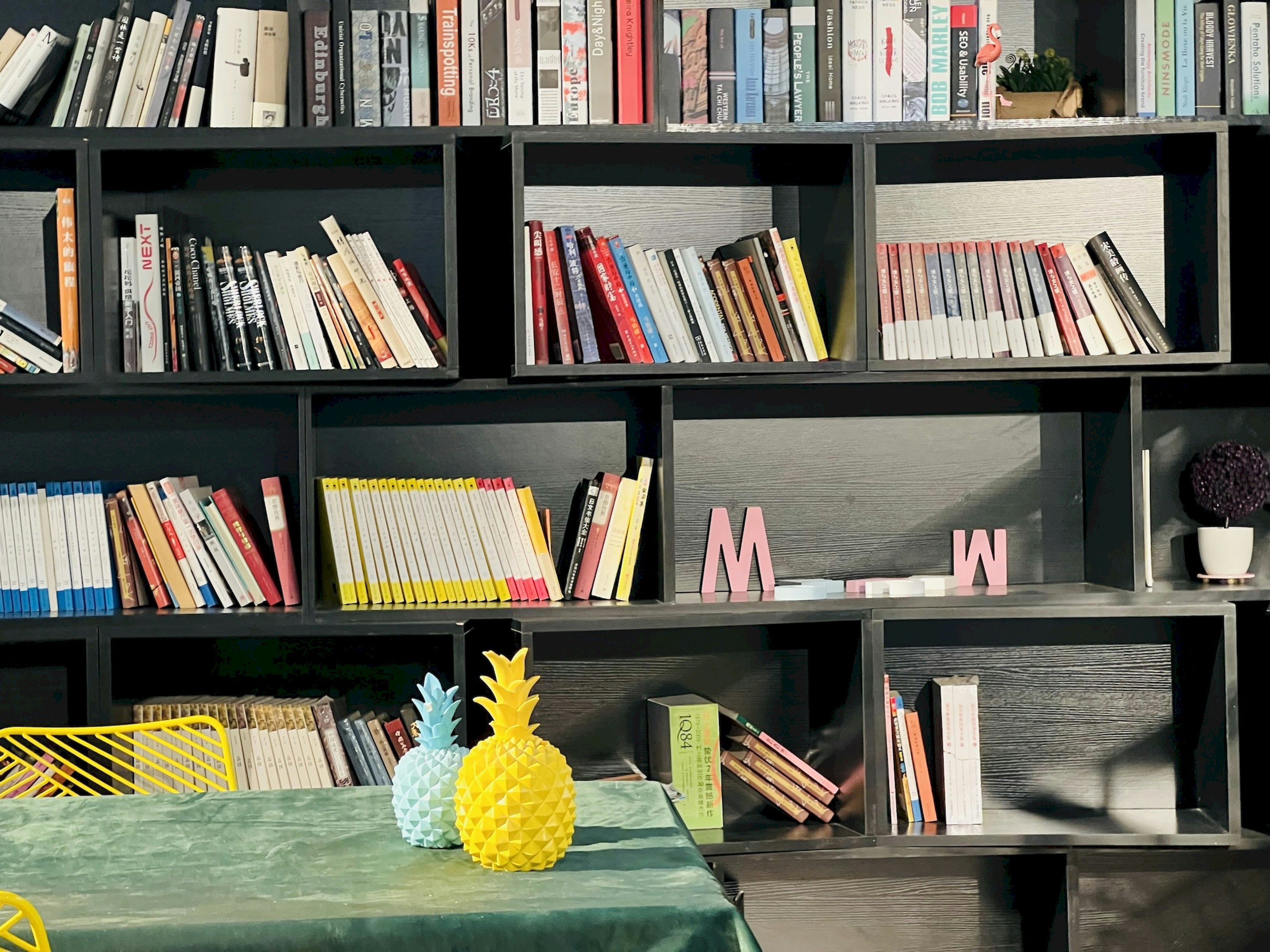 Pineapple Duet on a Green Table in Front of a Bookshelf
