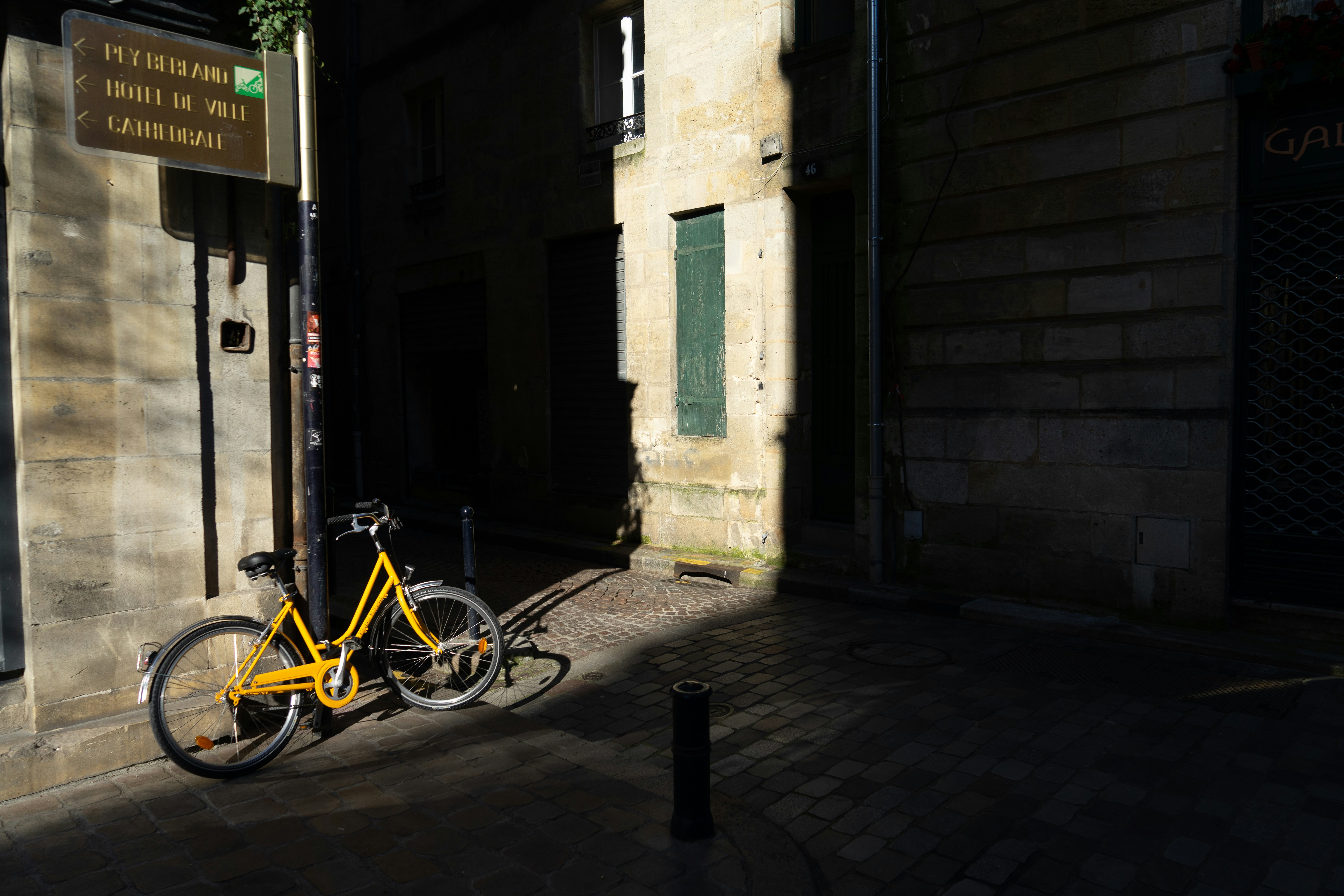 a yellow bike parked on a sidewalk