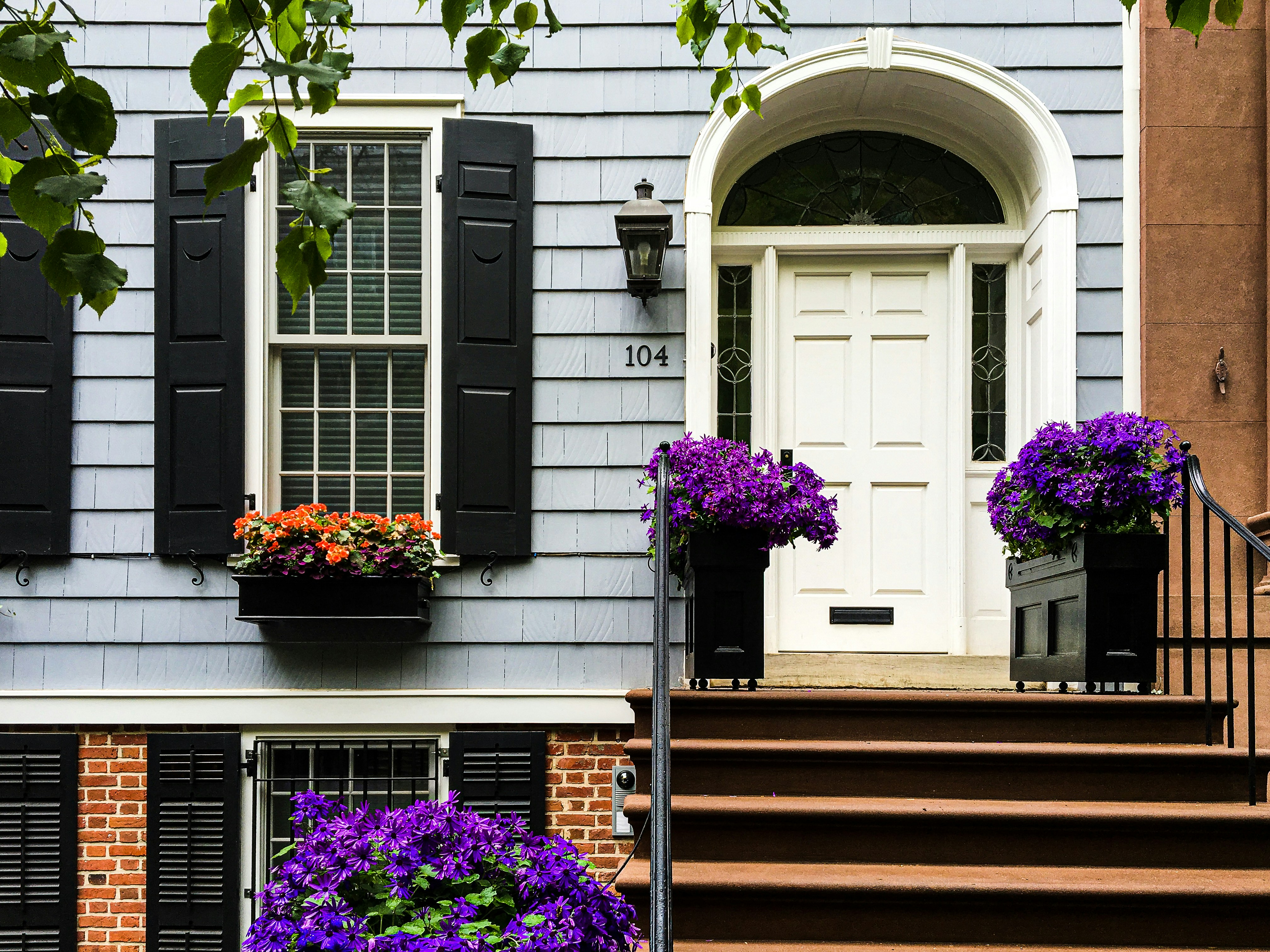 A building with a few windows and flowers in the front photo – Free New ...