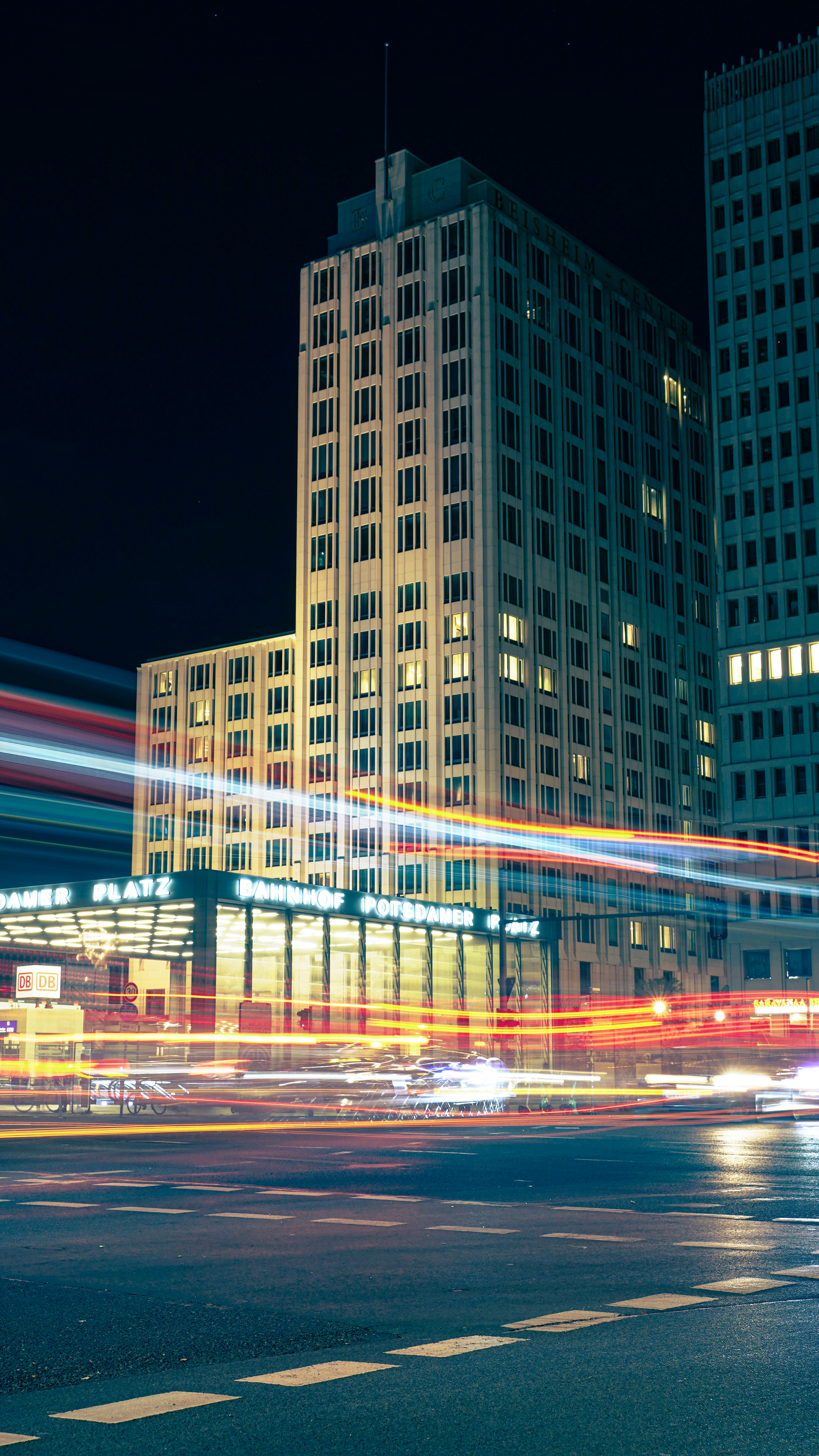 Illuminated buildings and vibrant light trails capture the energy of a bustling city at night.
