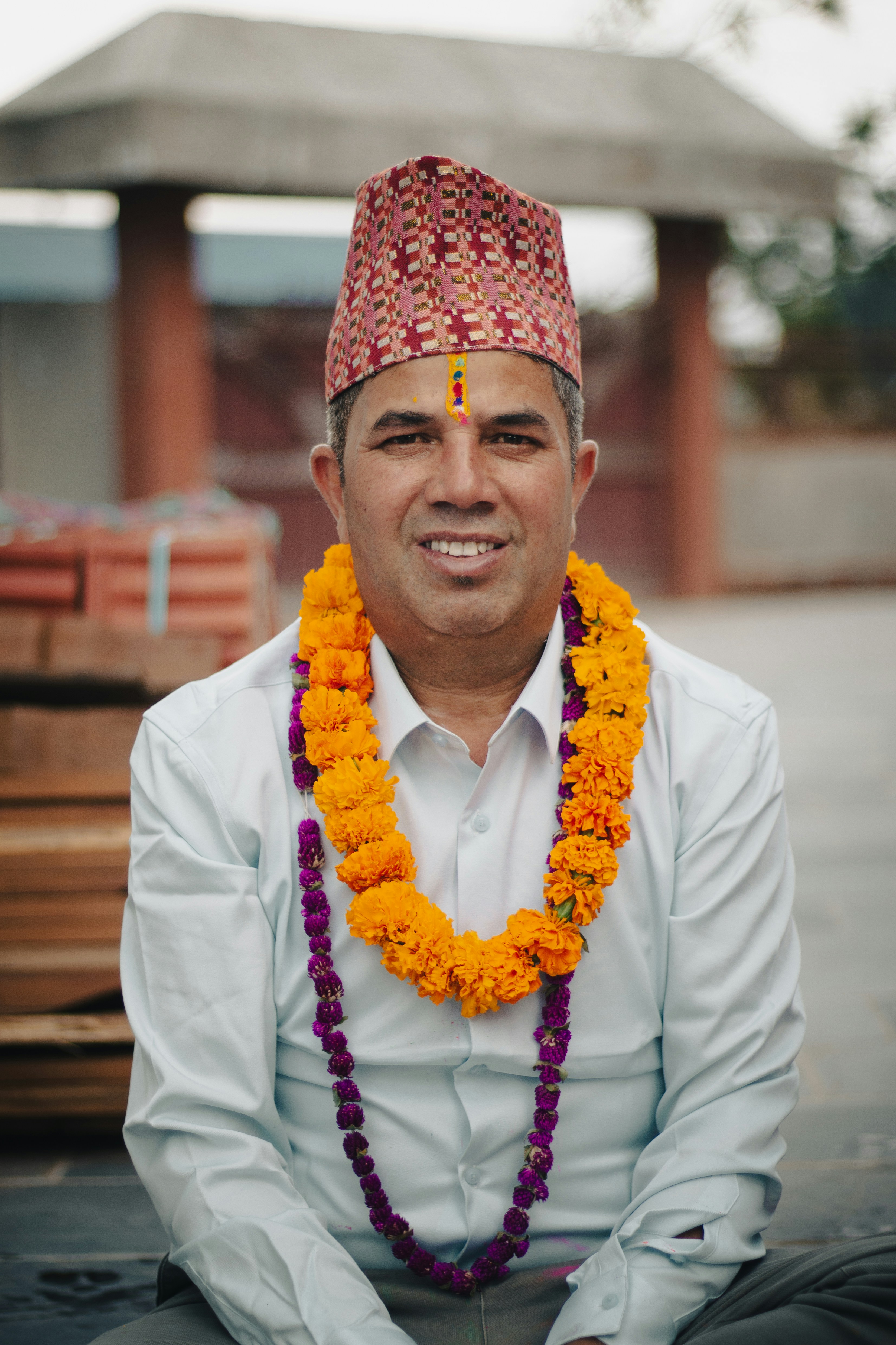 a man wearing a colorful headdress and a white shirt