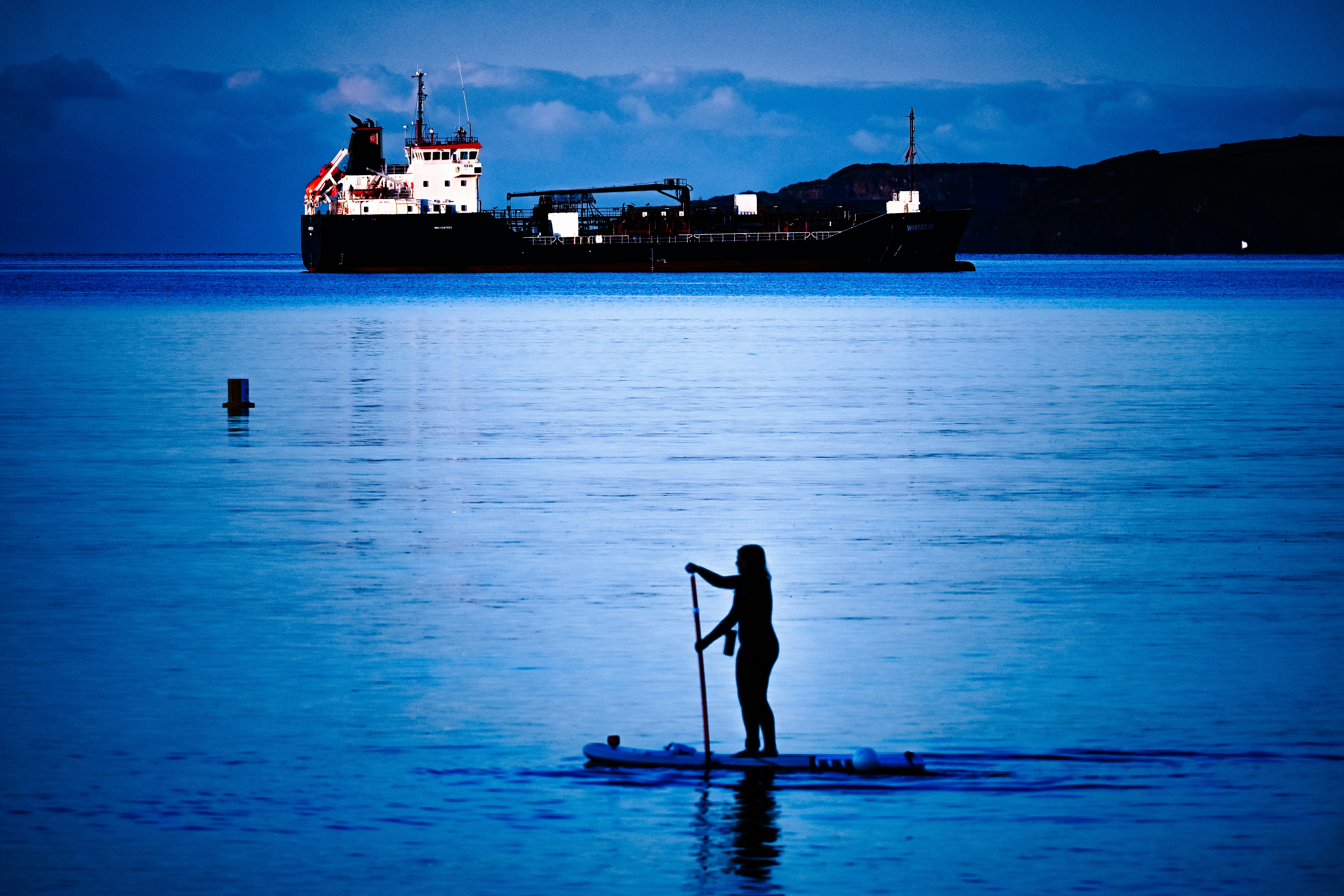Serenity on the Water: A Paddleboarder's Evening Journey