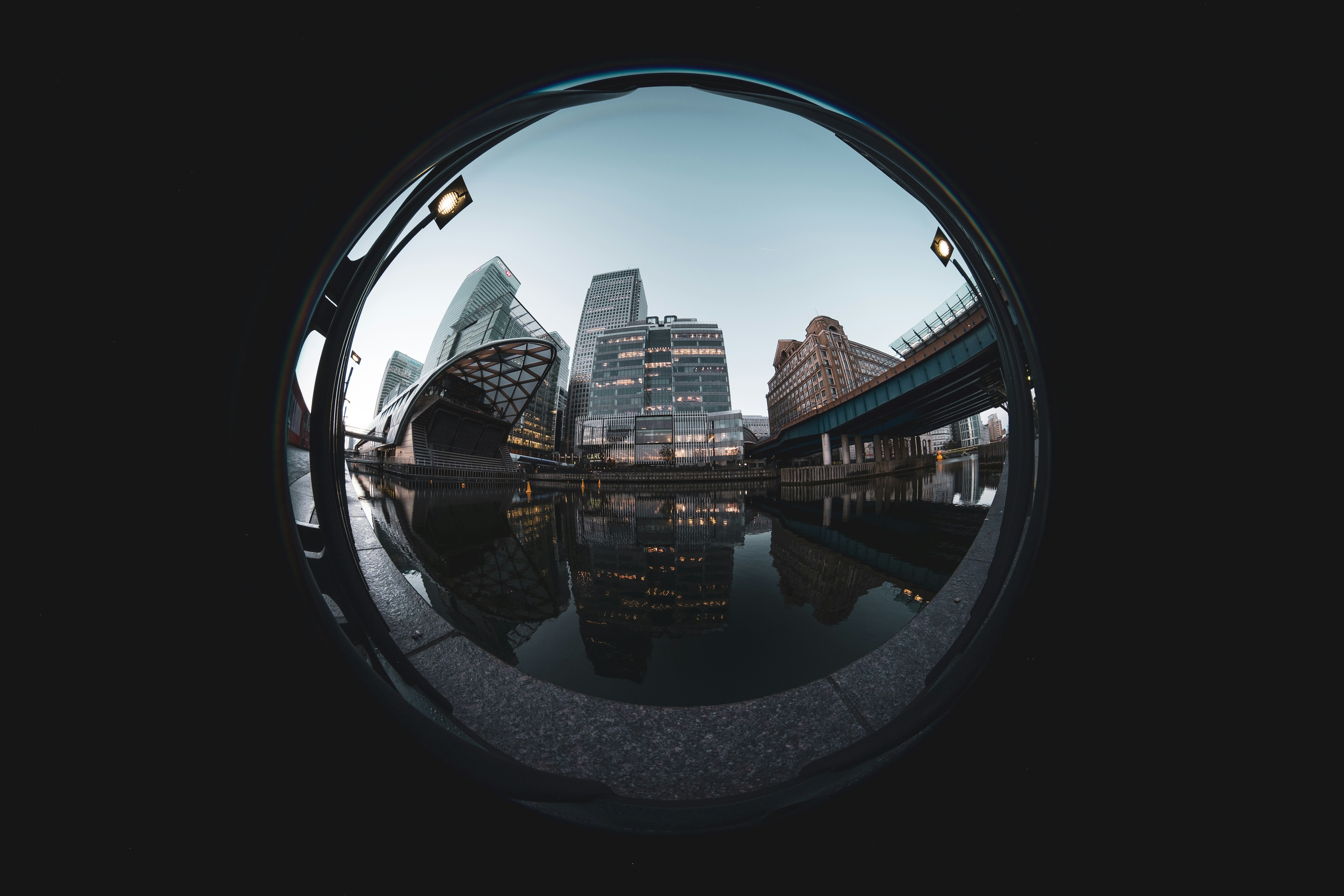 A view of a city through a circular window photo – Free Canary wharf ...