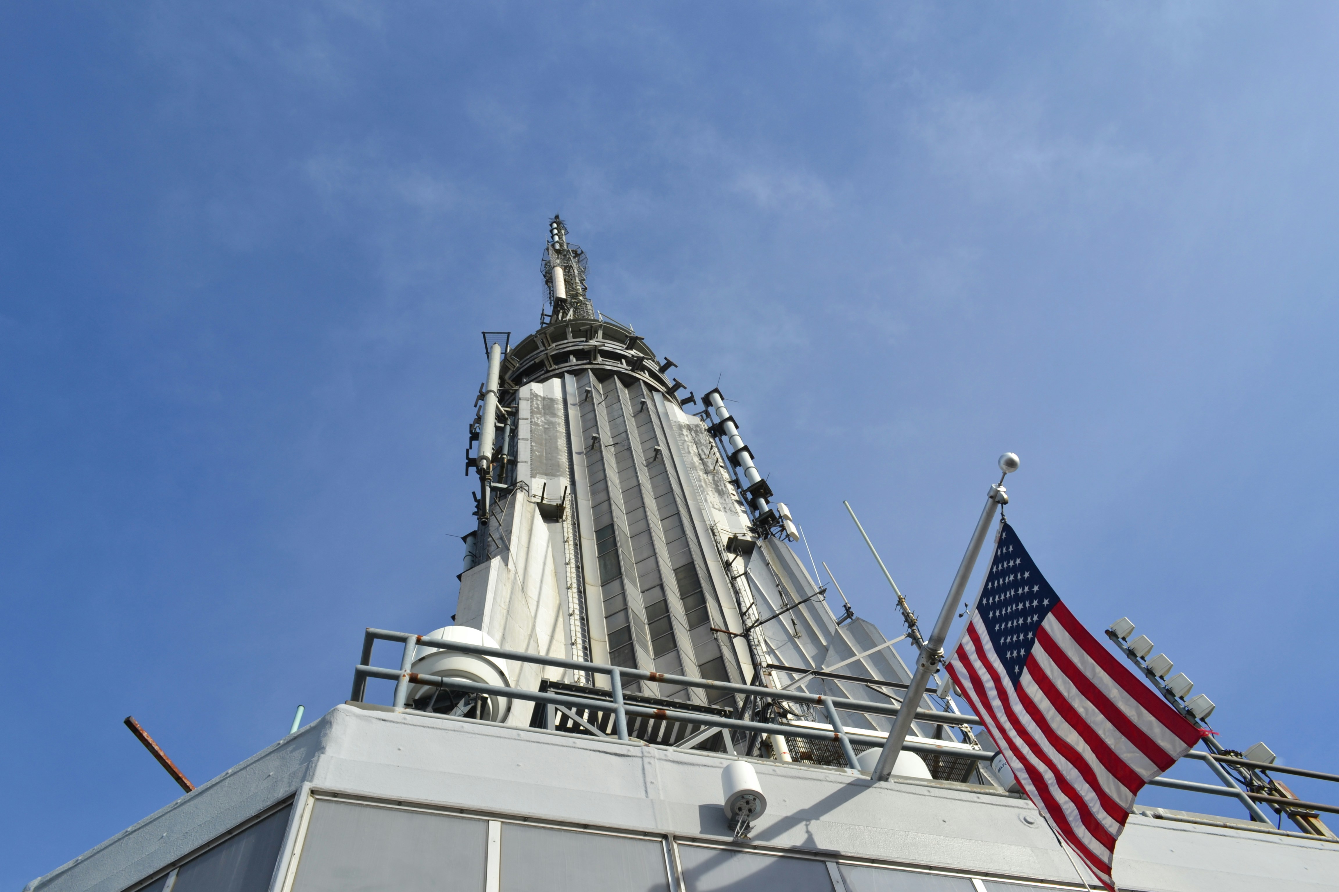Skyward Crown Over a Rooftop: Spire, Railings, and a Flag