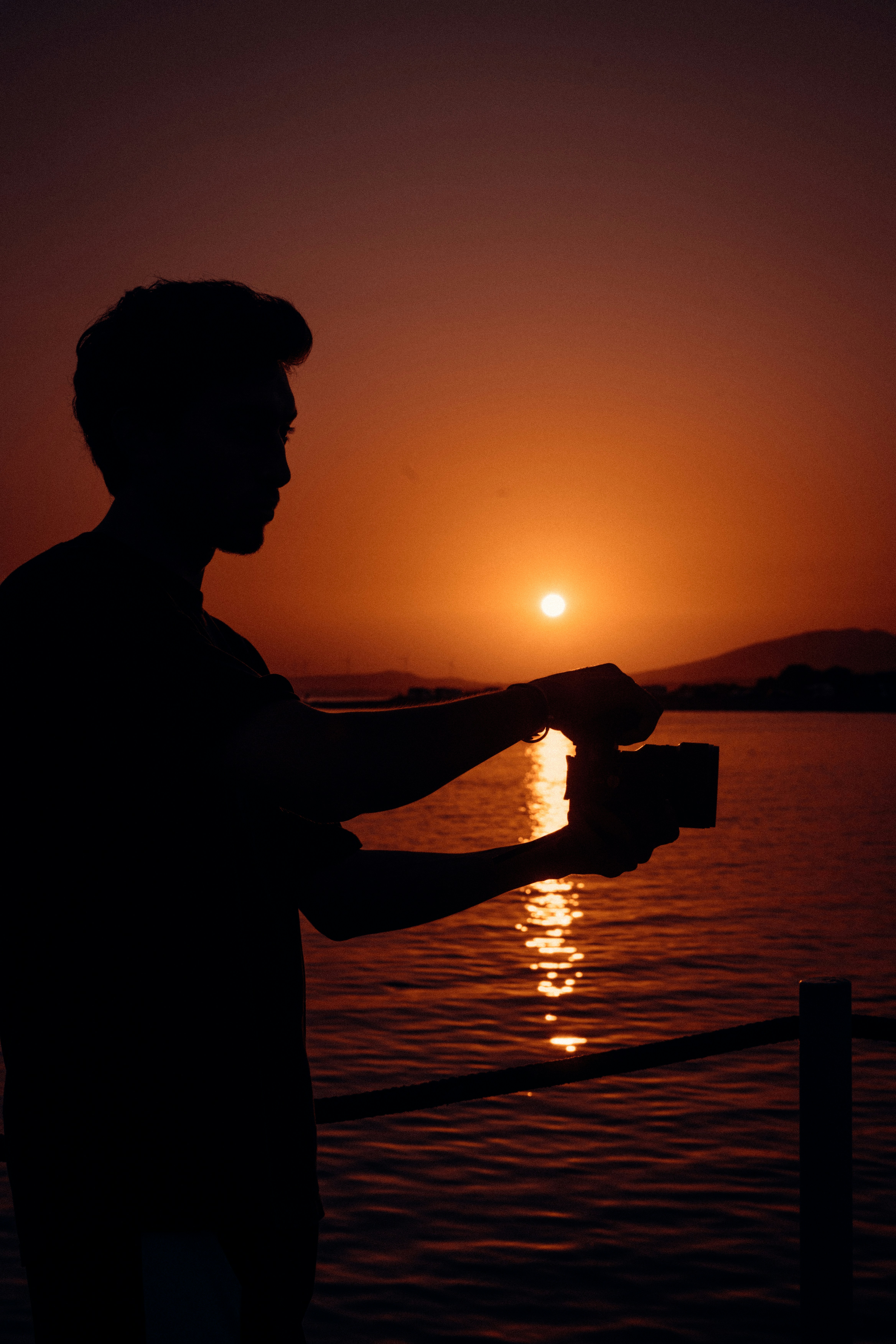 Silhouetted Moment: A Creator Captures Sunset with a Handheld Cam