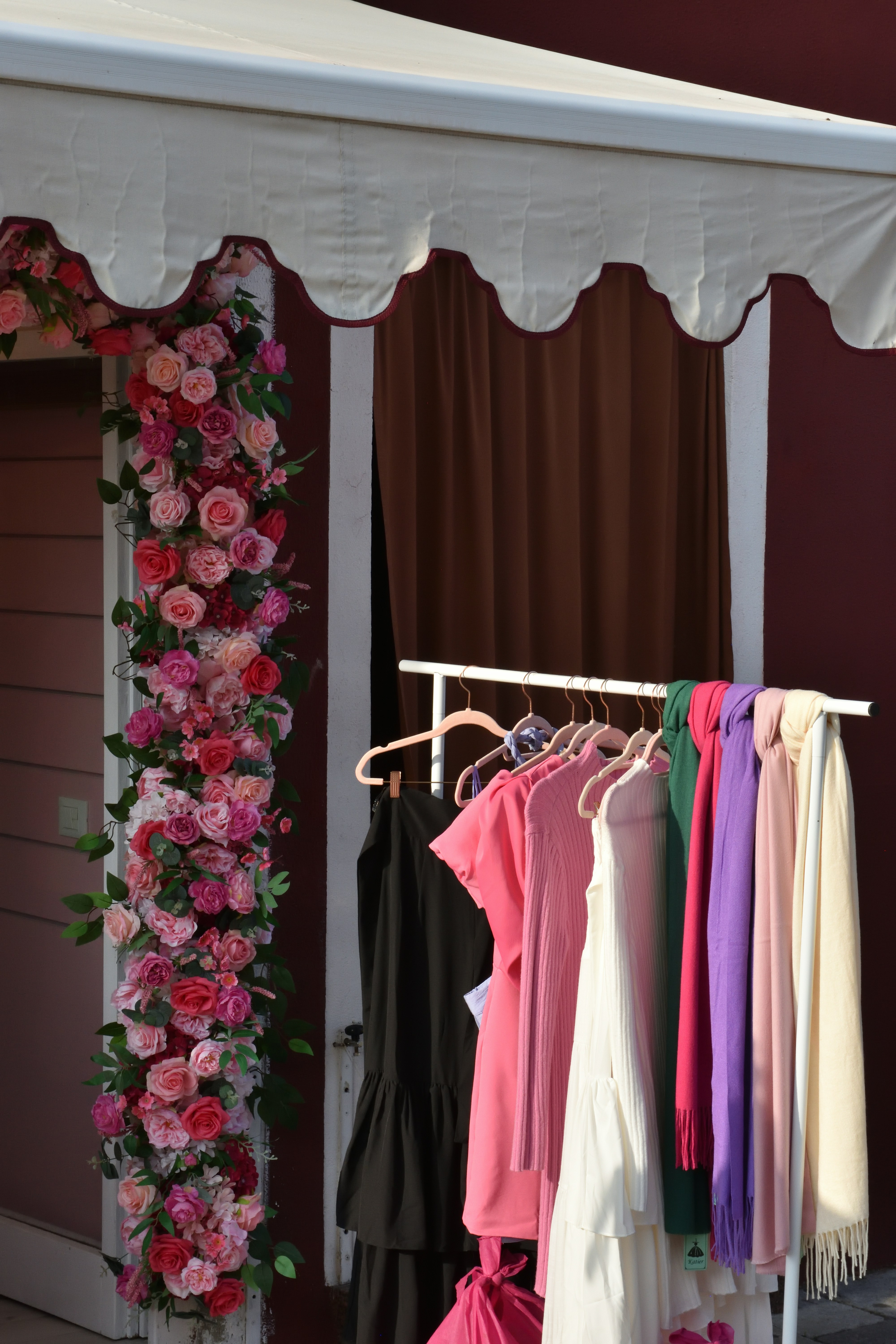 Pastel Rose Archway Framing a Rainbow Wardrobe Under a White Canopy