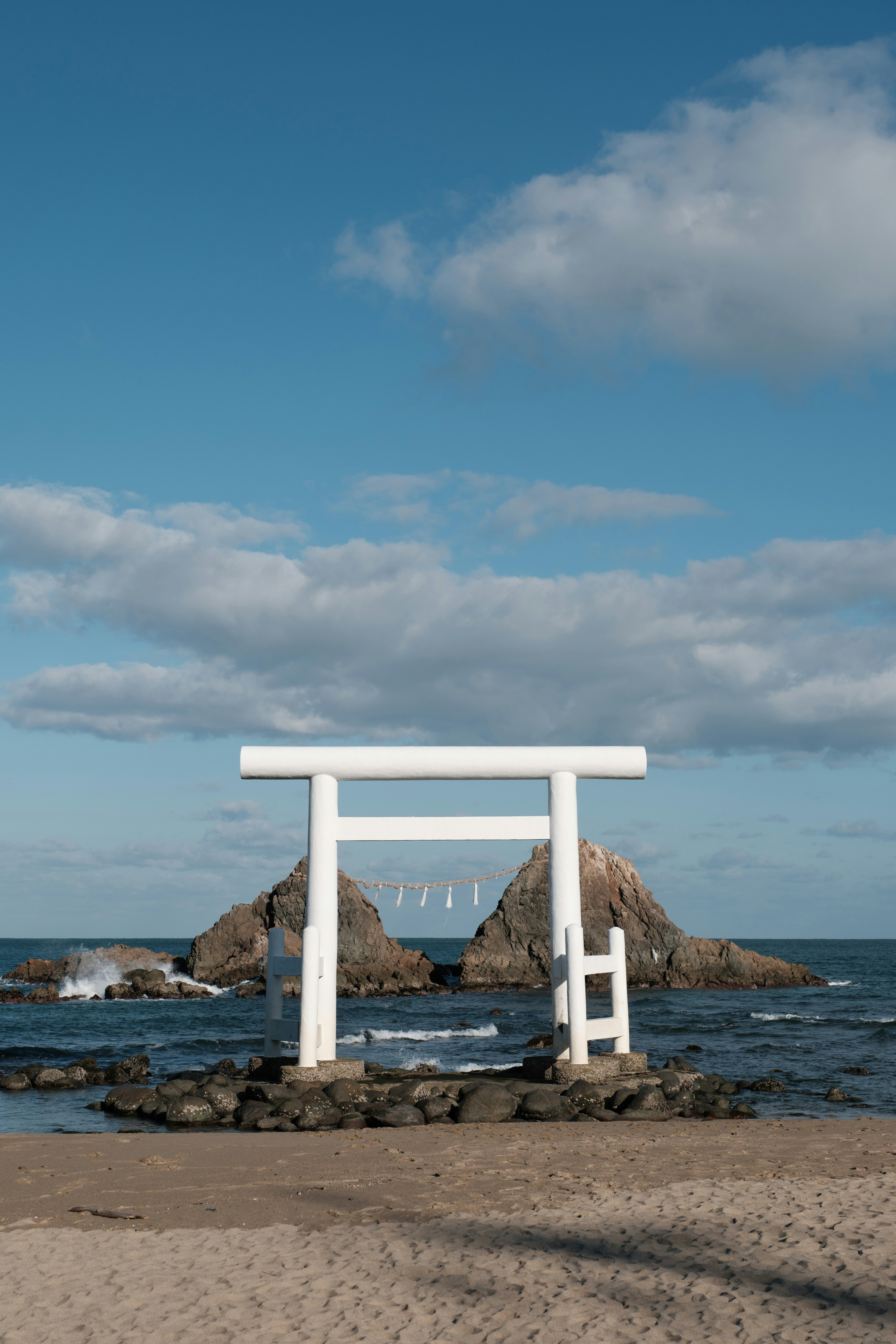 White Torii on a Rocky Jetty: Sea, Sky, and Shimenawa