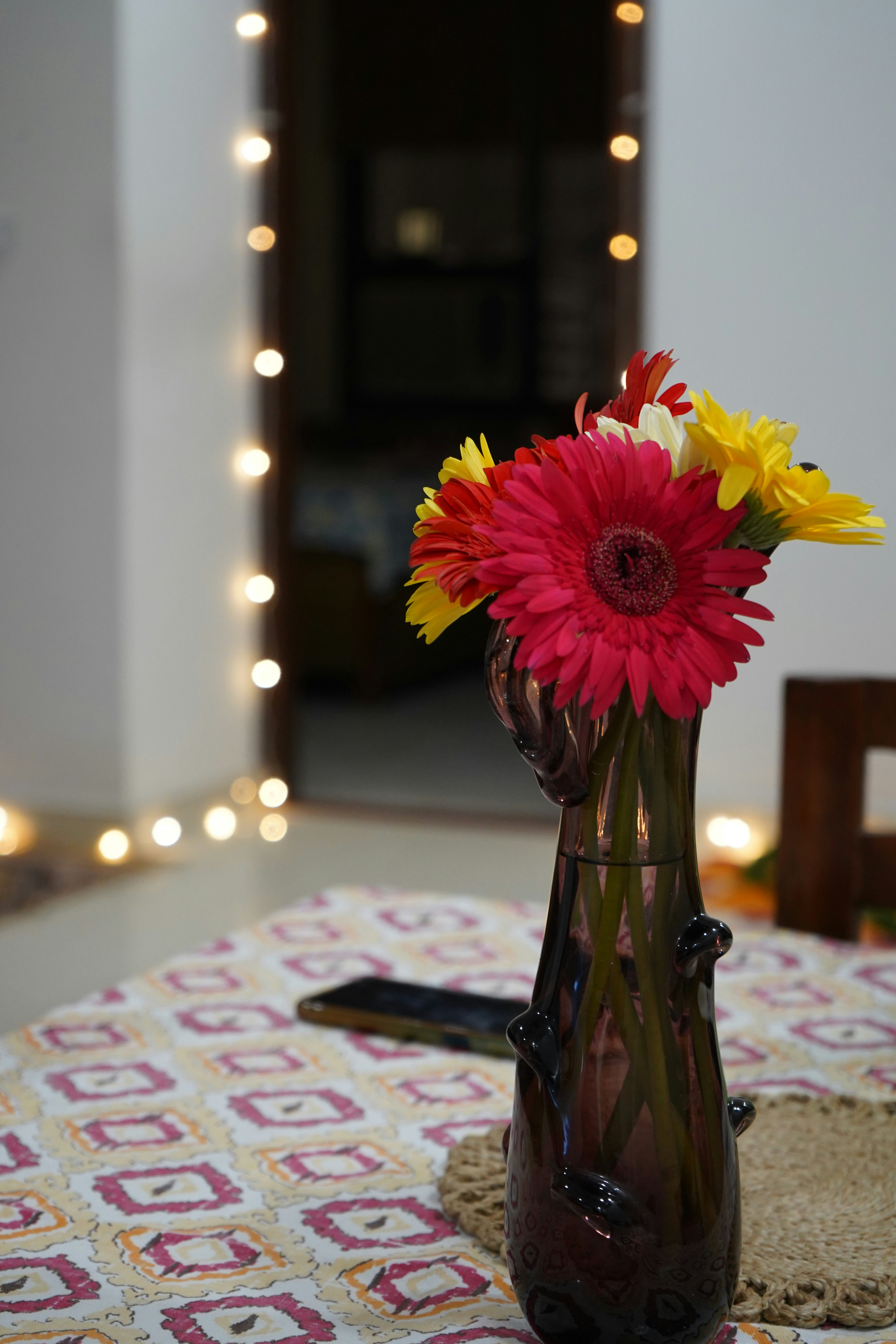 Vivid Gerbera Bouquet in a Glass Vase Surrounded by Warm Vanity Lights
