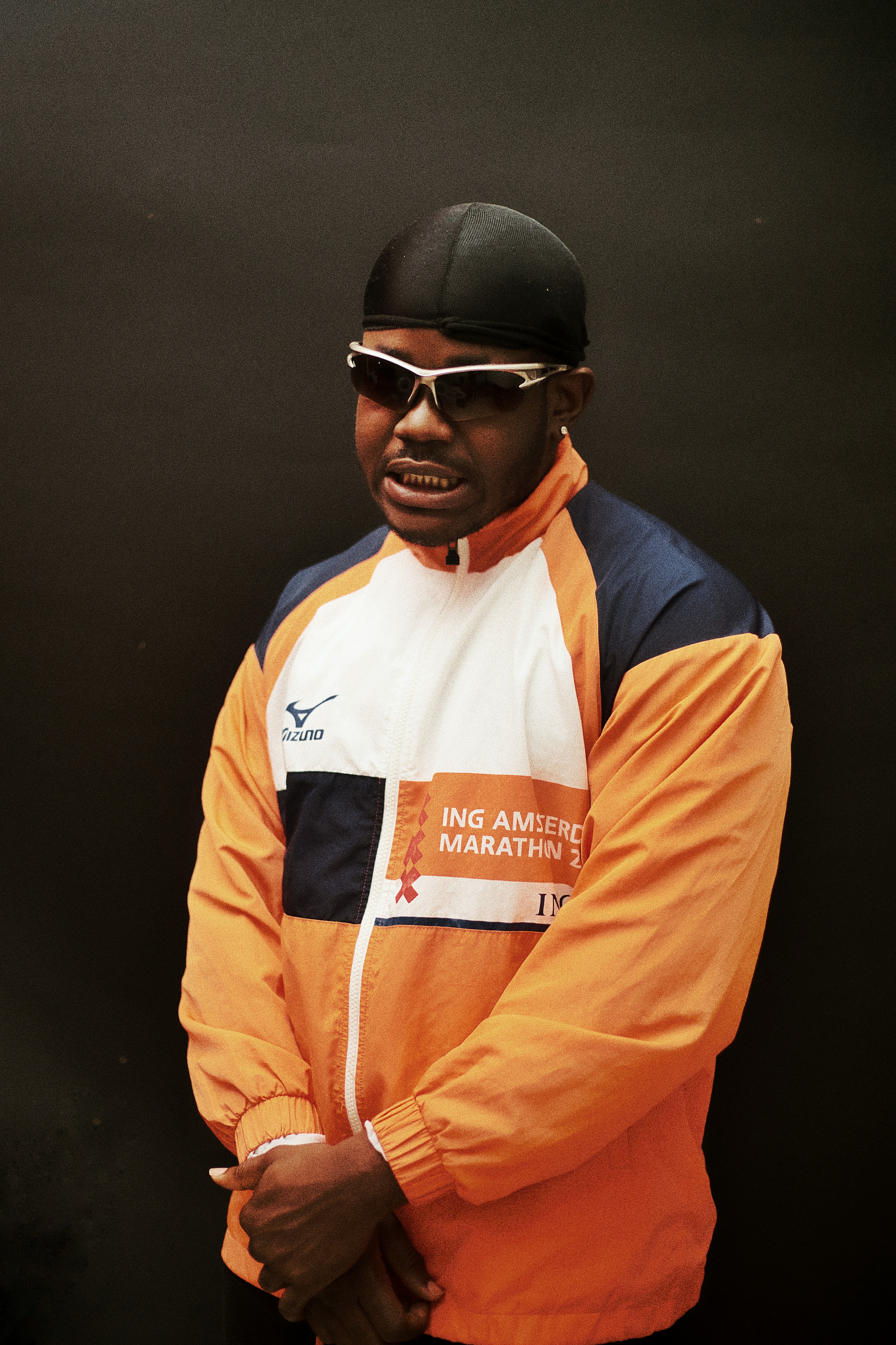Studio Portrait: Orange-Jacket Runner in a Dark Backdrop