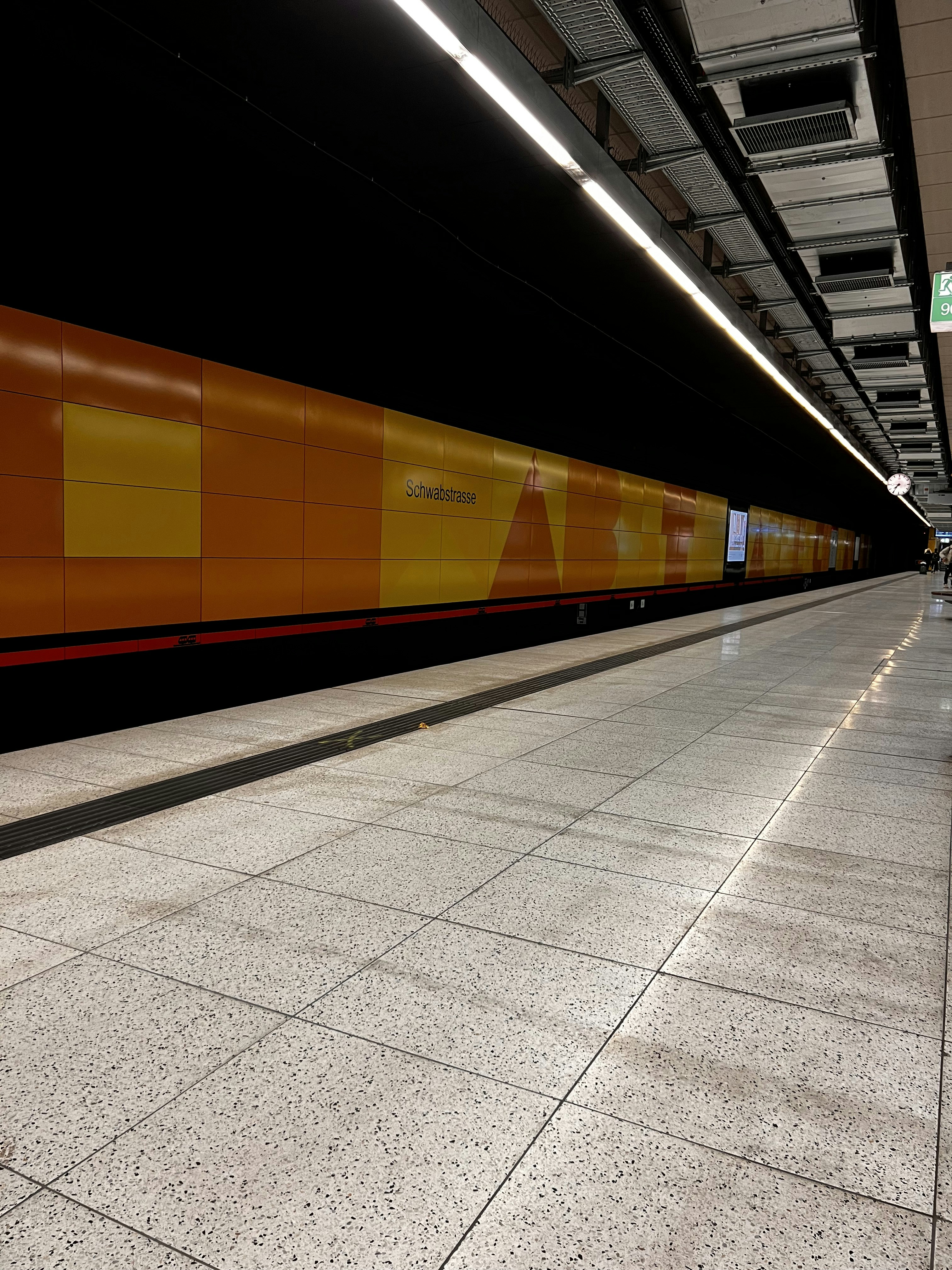 Orange Subway Wall: Long Platform Reaches into the Darkness