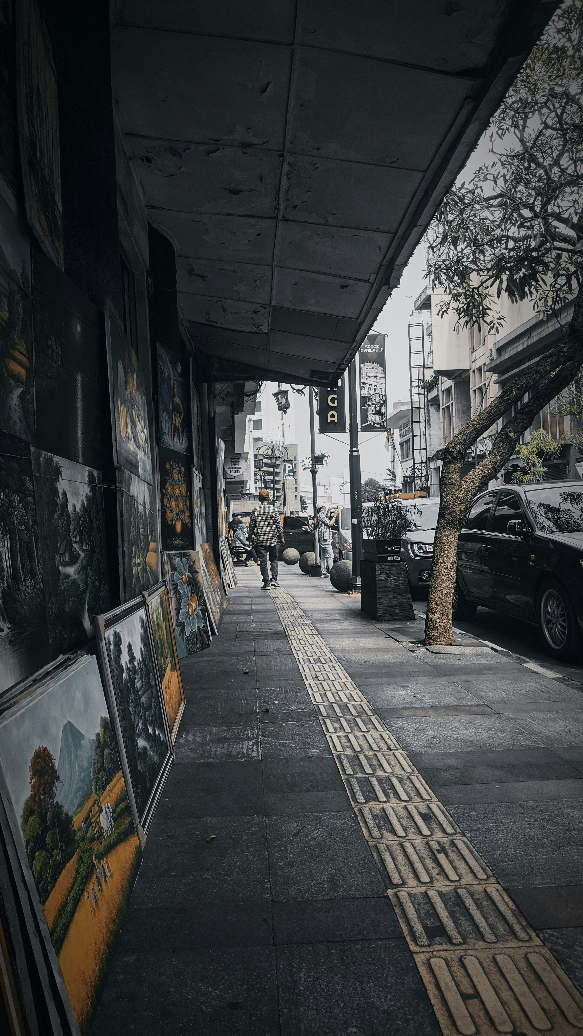 a sidewalk with cars and people