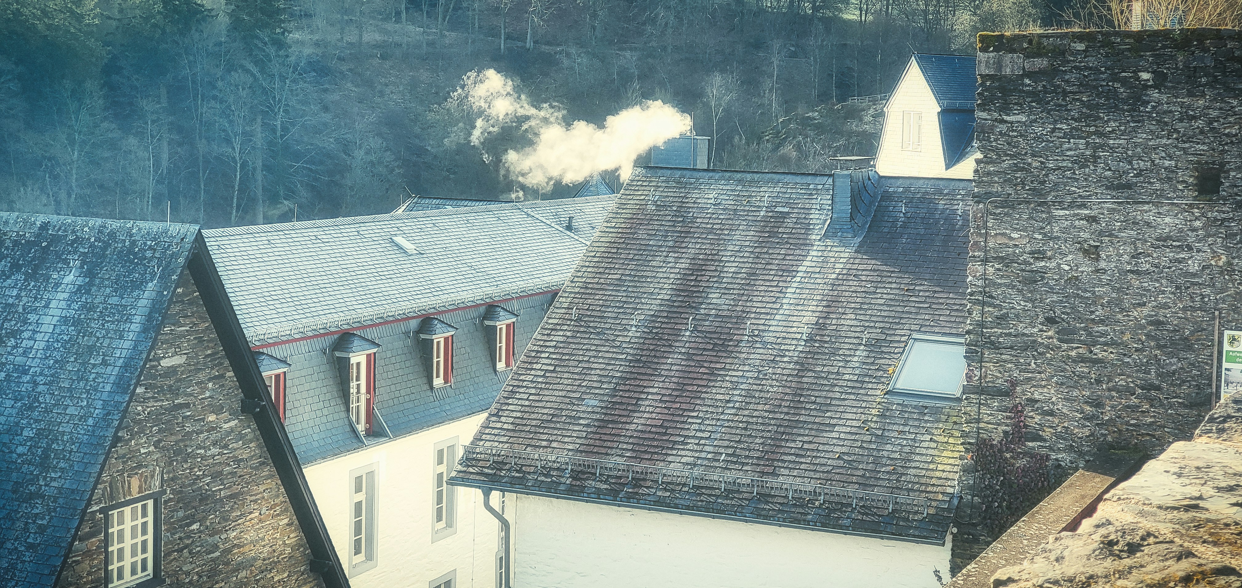 Foto Un grupo de casas con humo saliendo de ellas – Imagen Alemania ...