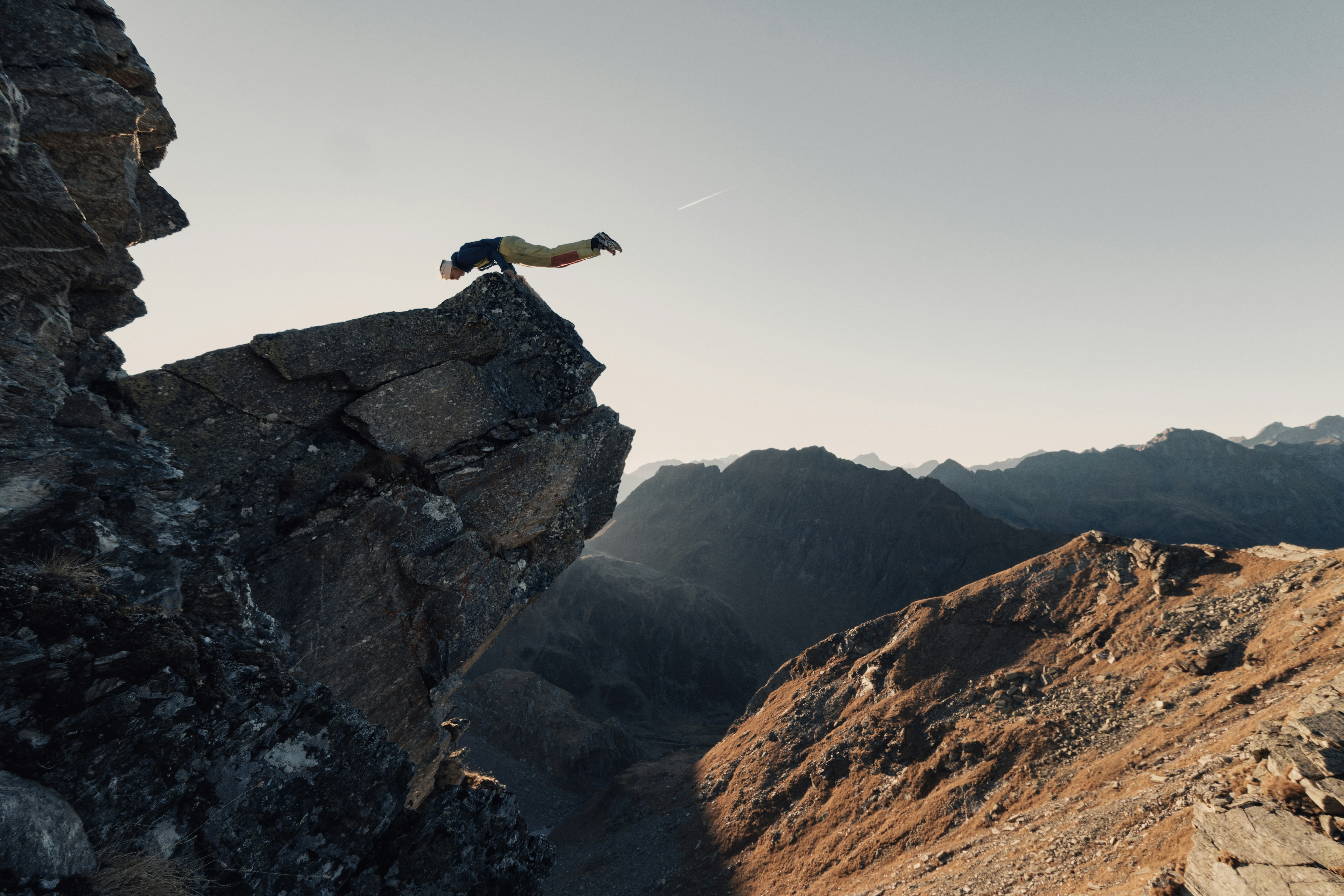 A person jumping off a cliff photo – Free Glove Image on Unsplash