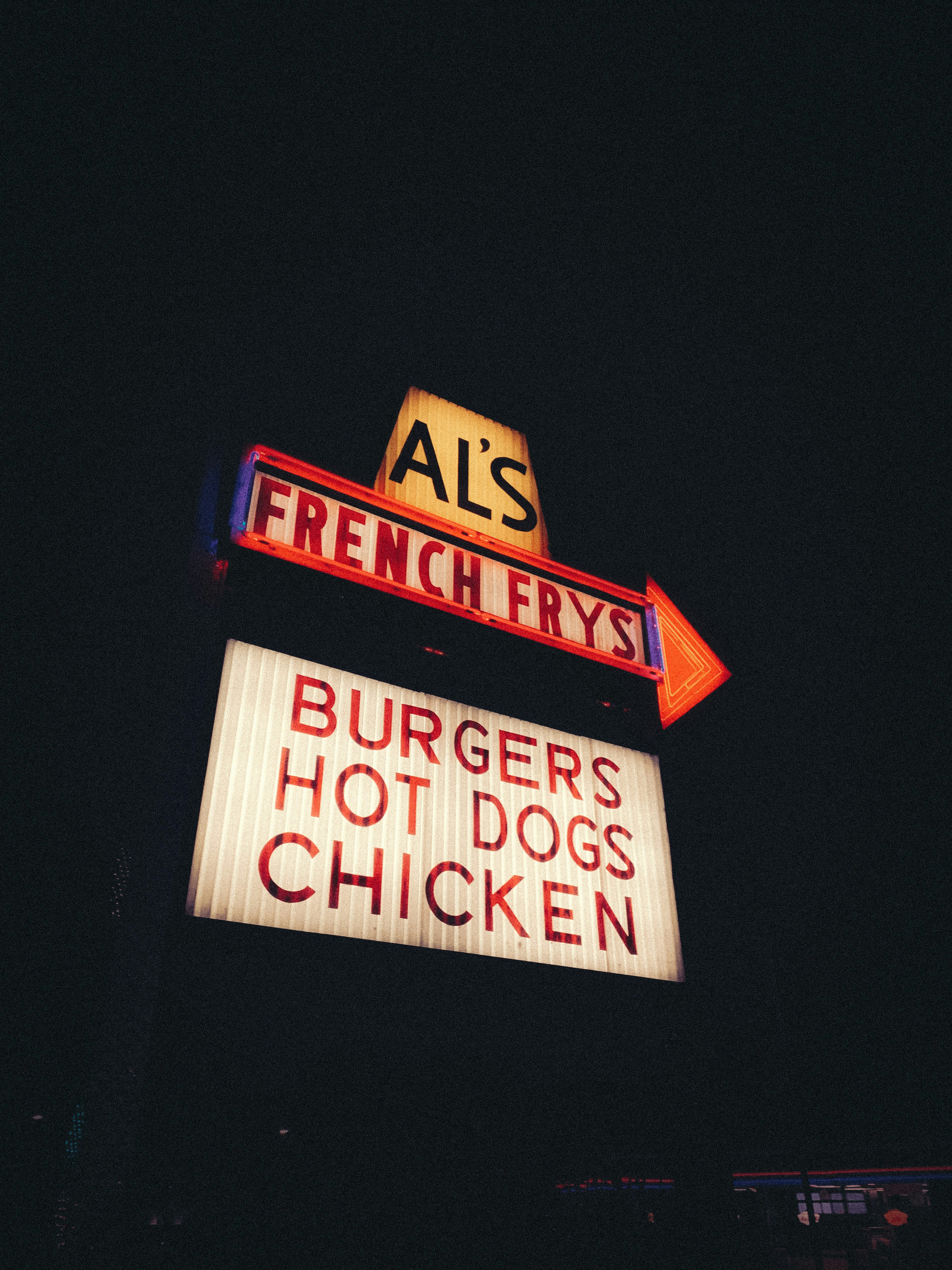 Neon Night Sign: Retro Fast-Food Arrow Lighting Up Burgers and Fries