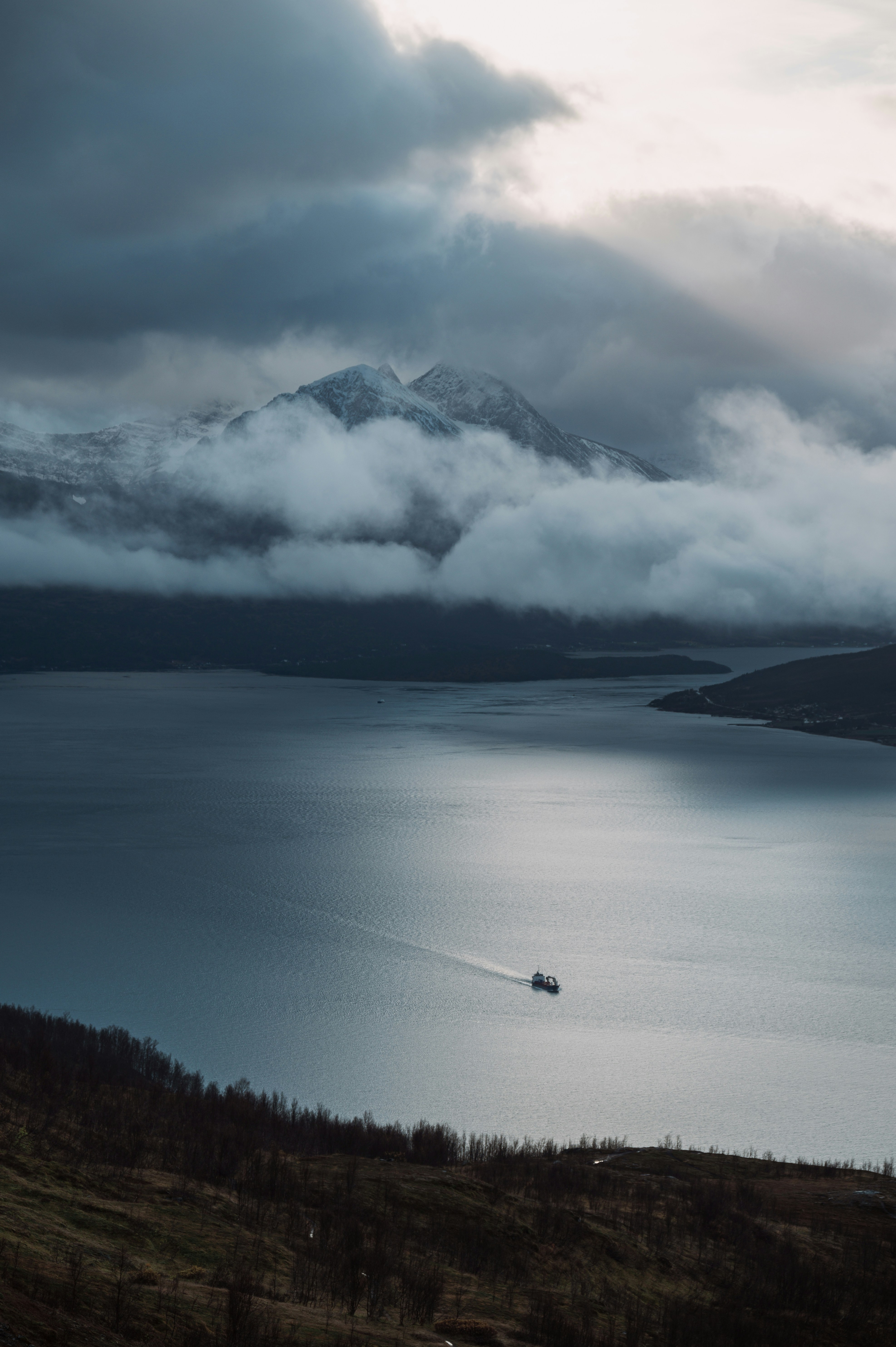 Misty Peaks Over a Quiet Fjord