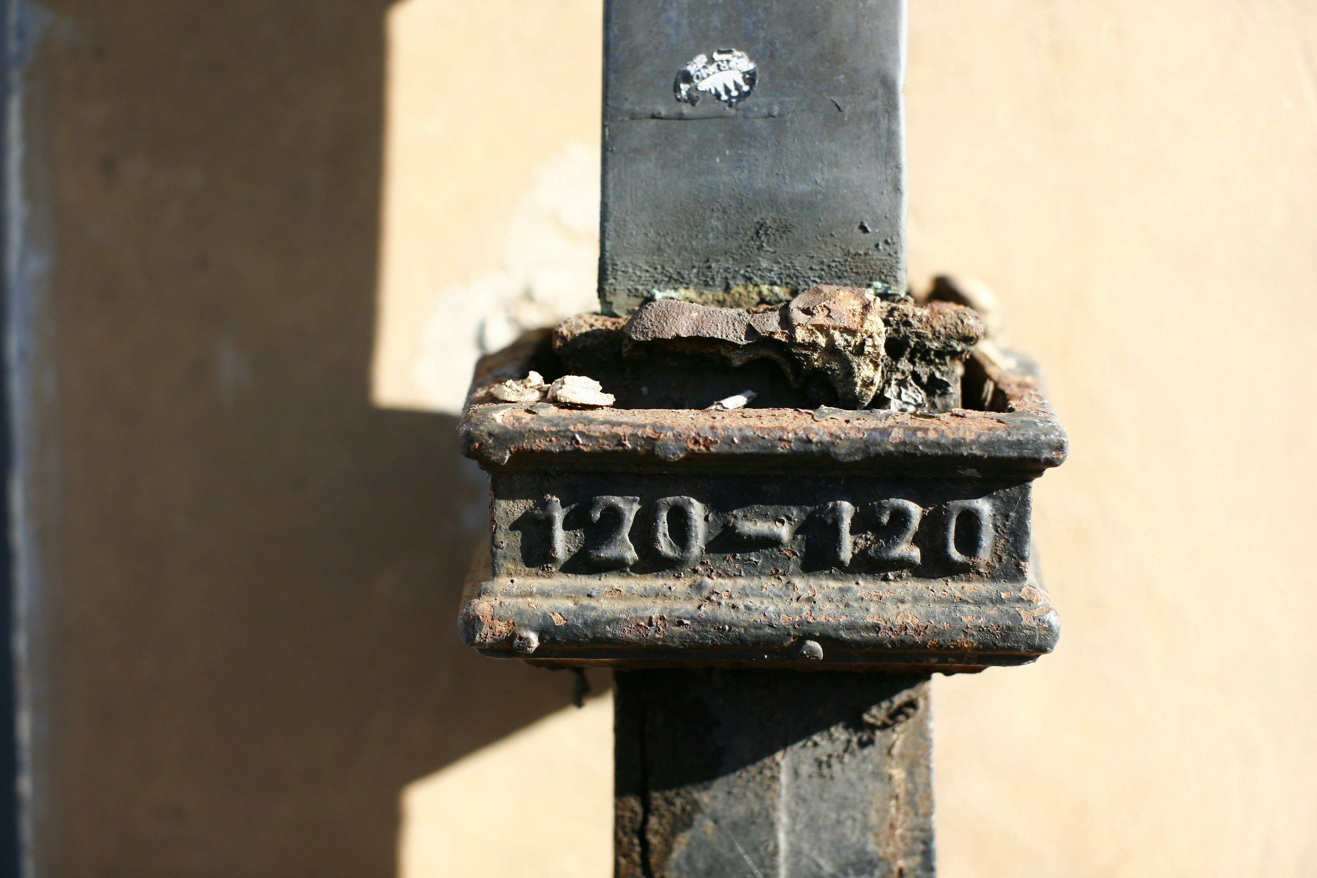 Rust-Stamped 120-120 Latch on a Sun-Warmed Wall