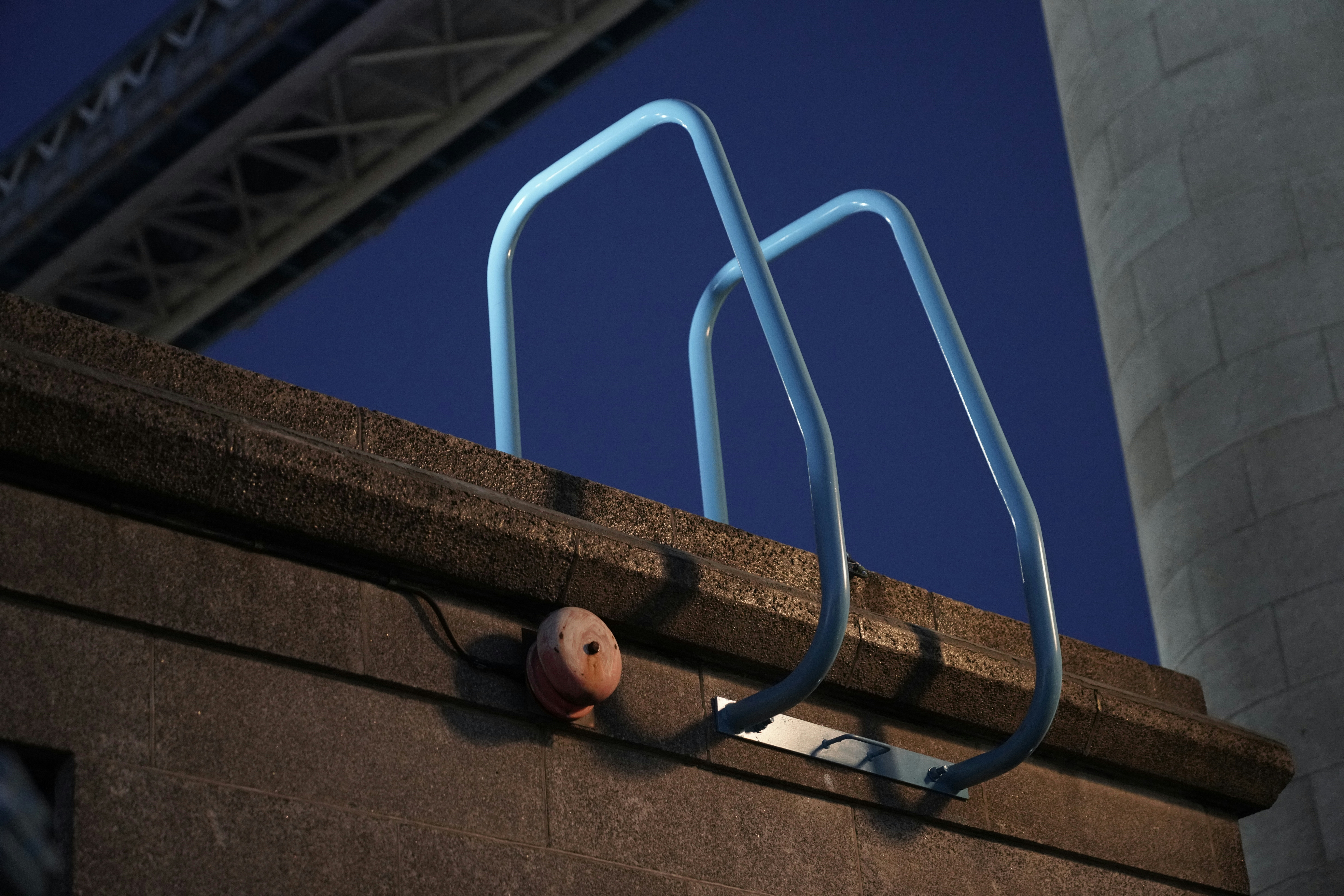 Azure Handrails Arc Over a Weathered Rooftop at Dusk