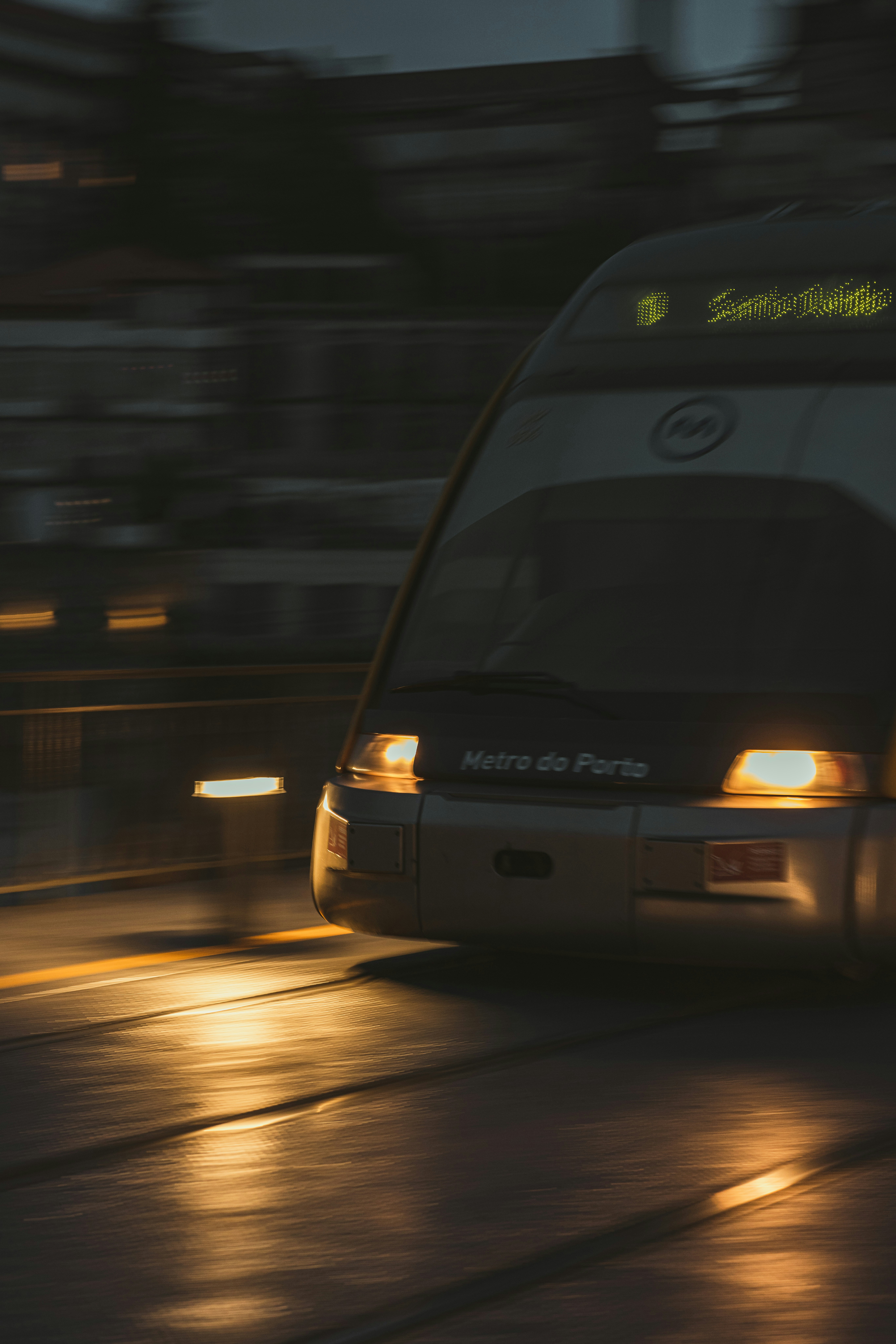 Glowing Front in Motion: A Night Metro Tram Cutting Through Rain-Slick Streets