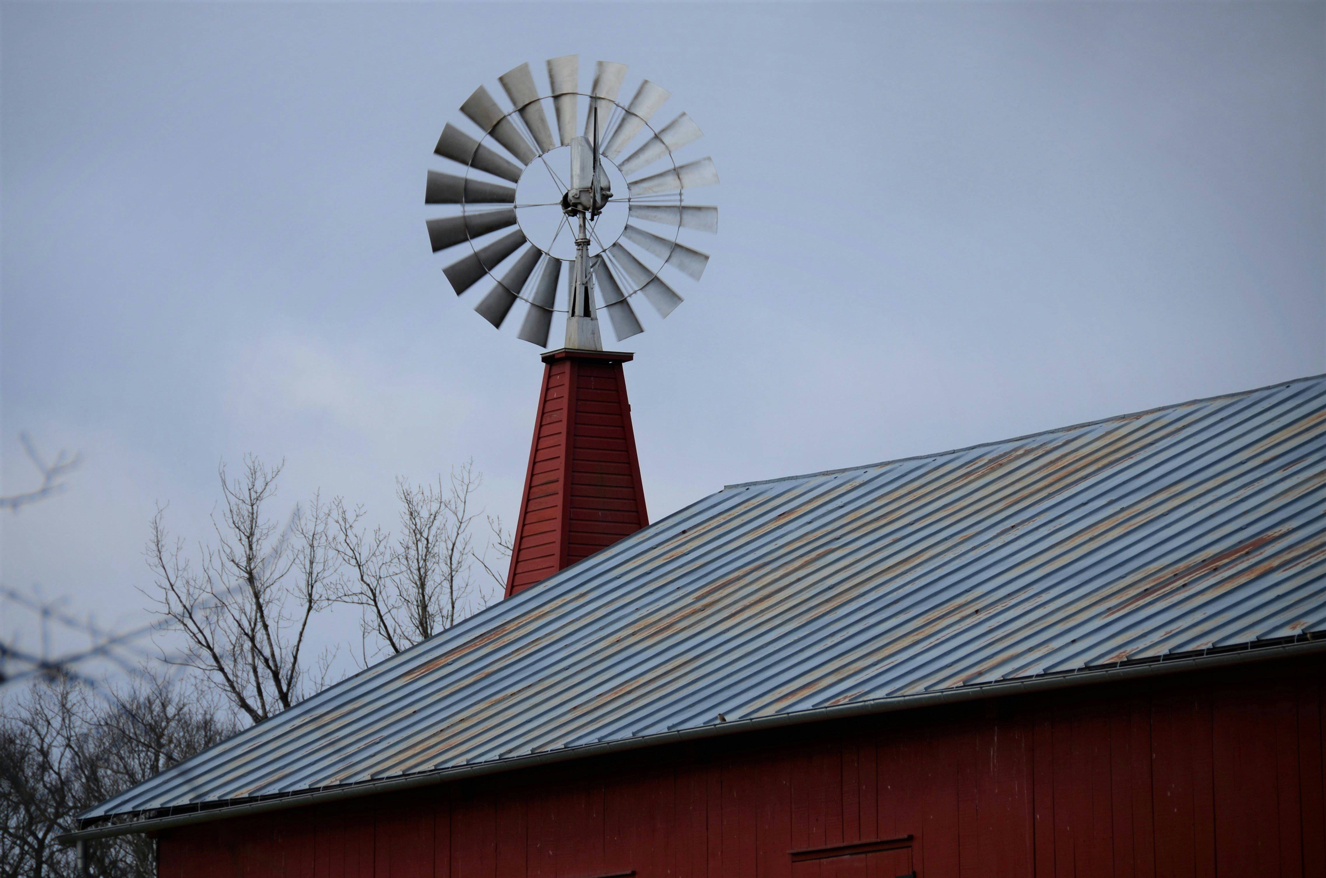 Windmill Sentinel Above the Red Barn Roof