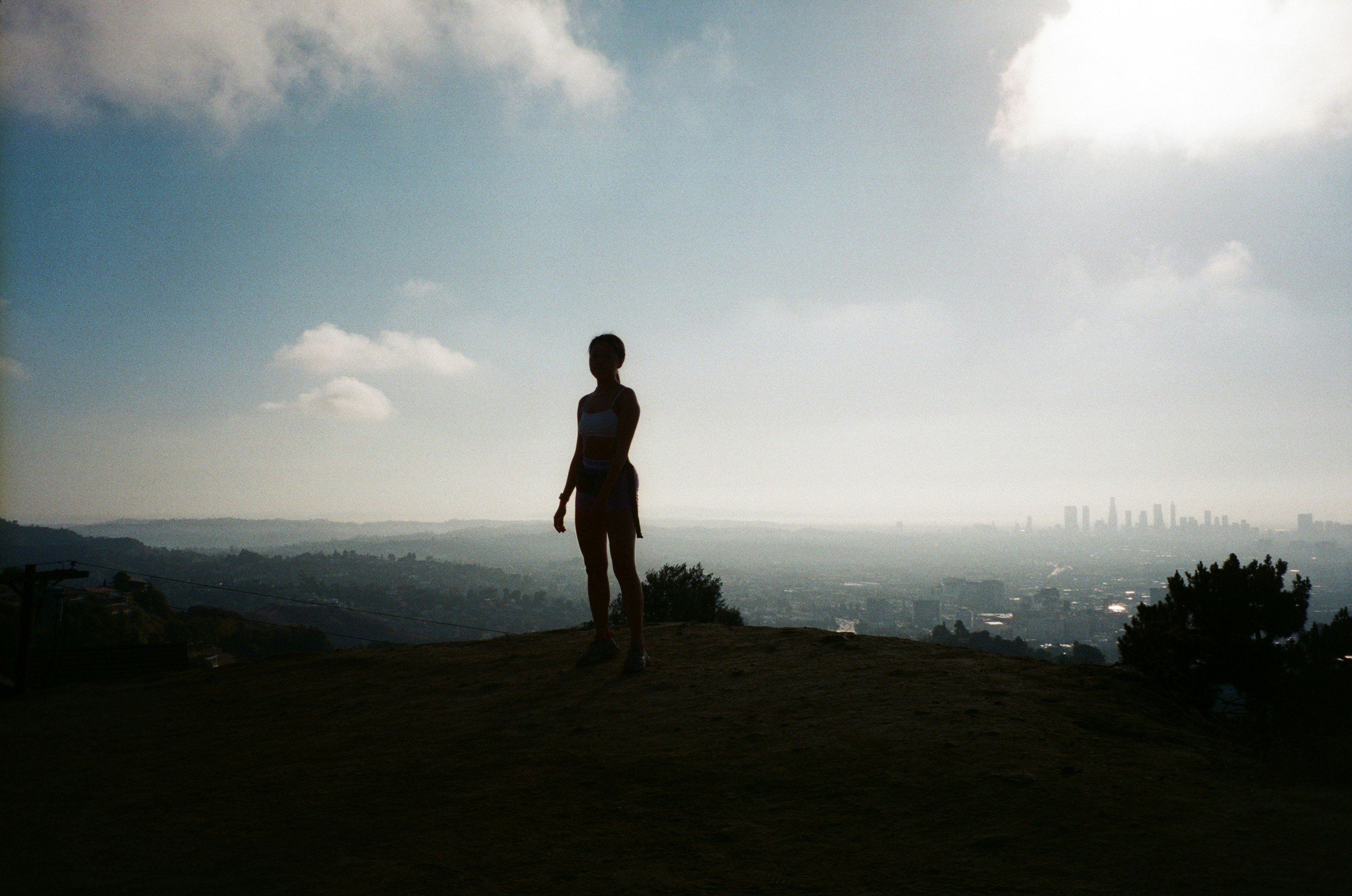 Lone Silhouette on a Ridge Facing a Distant Skyline