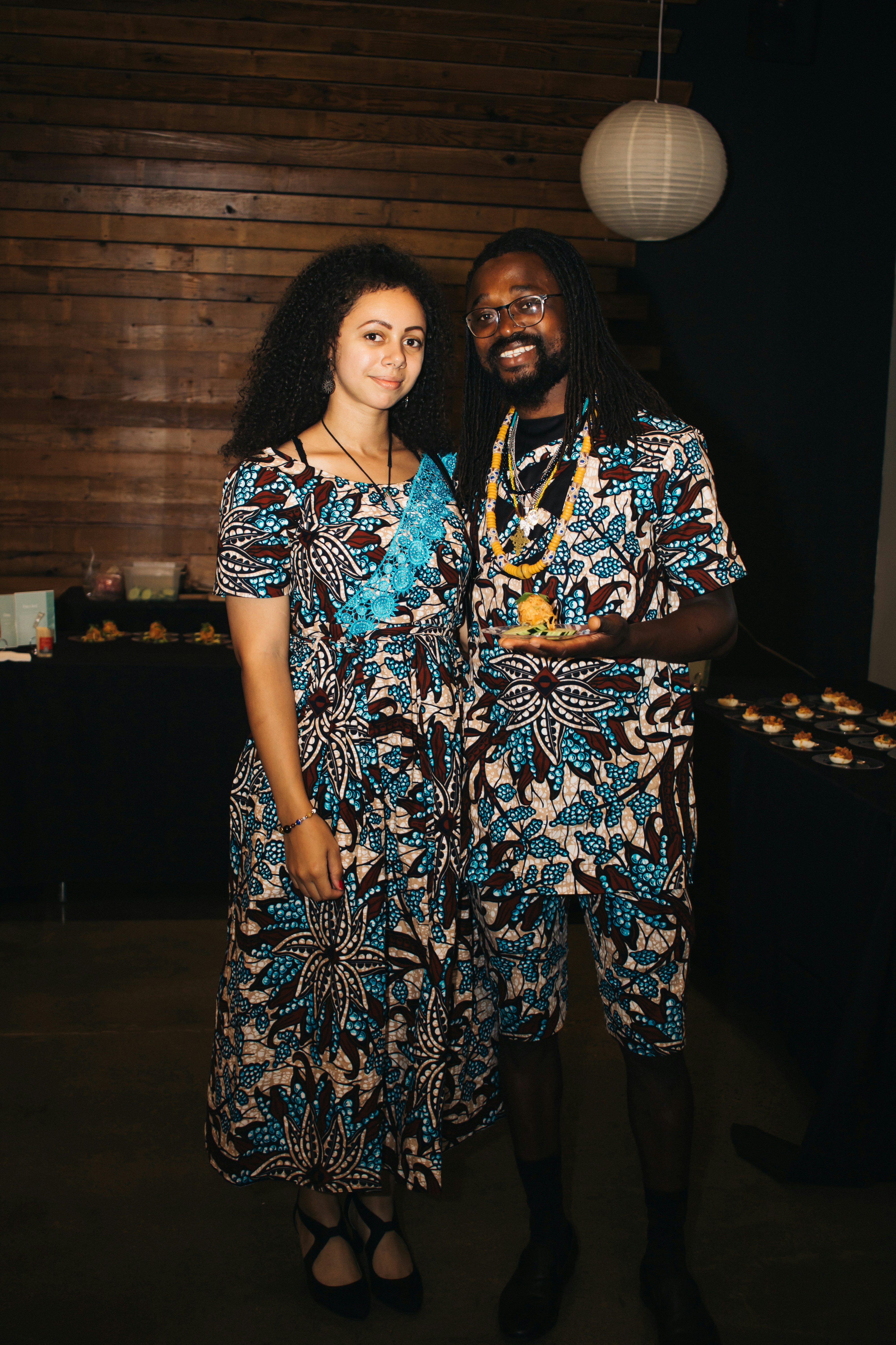 Patterned Affection: Duo in Batik at a Warm Indoor Gathering