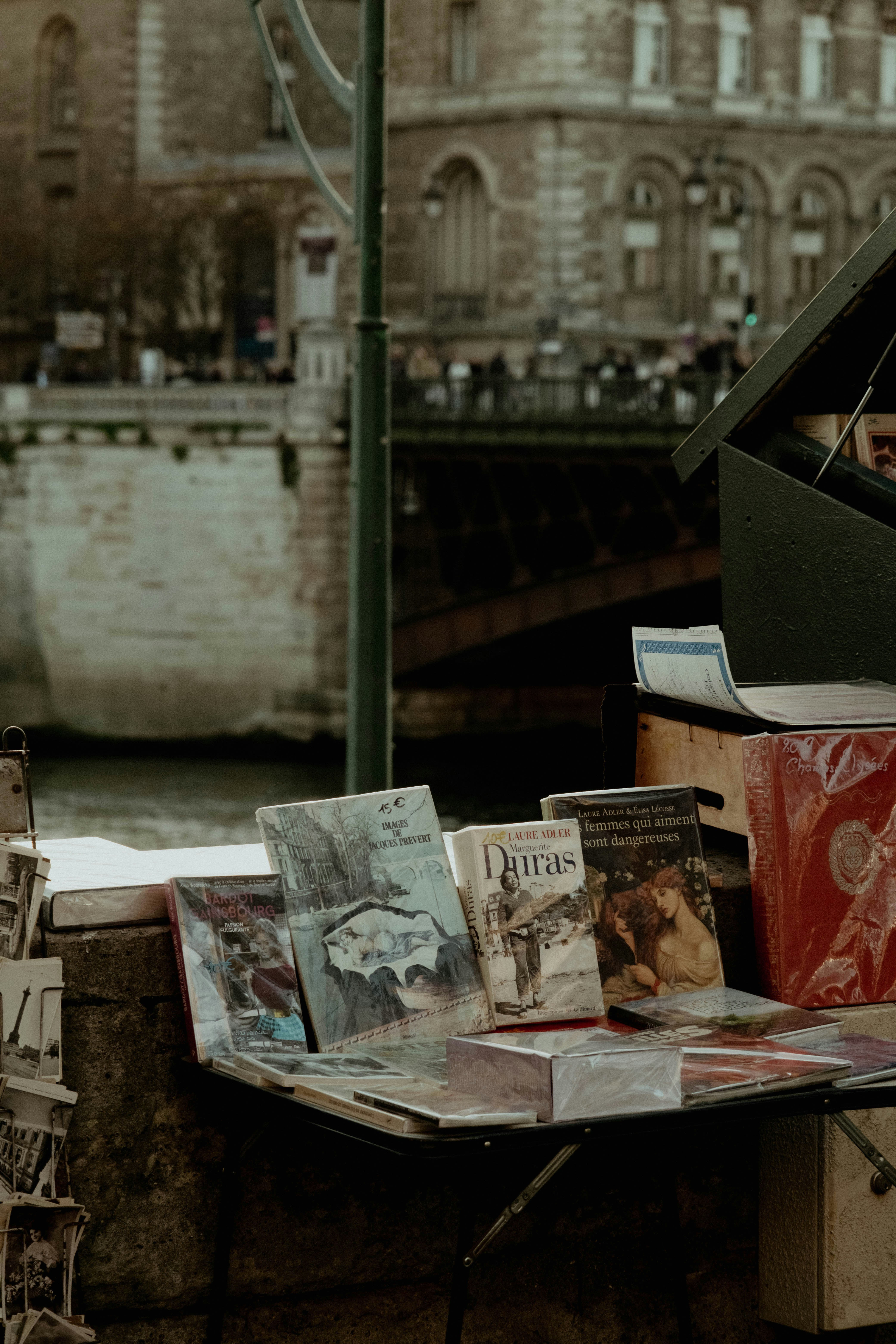 Riverside Newsstand at Dusk: Weathered Pages Framed by a Historic Bridge