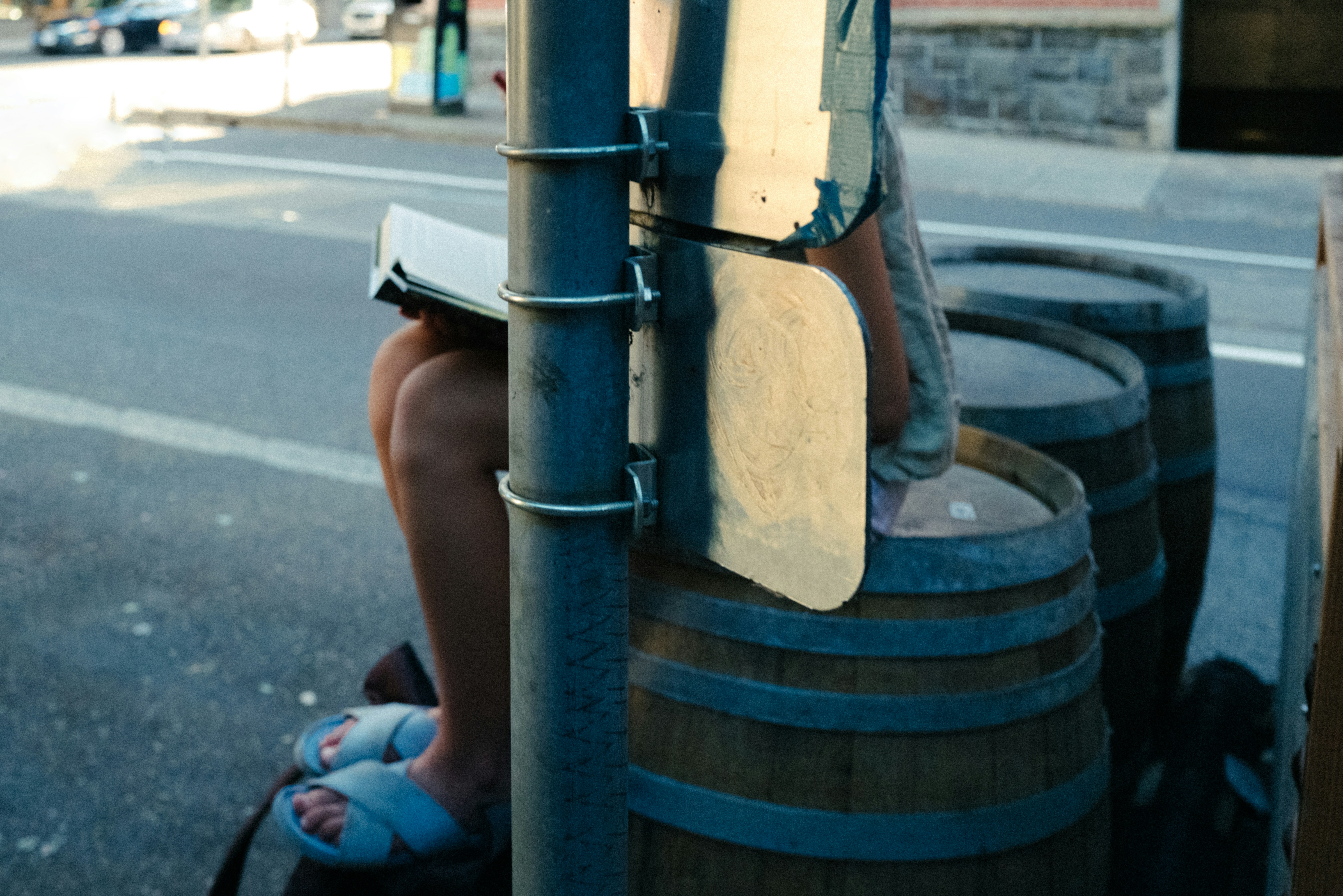 Edge of Calm: Street Pause by a Metal Post and Barrel Bench