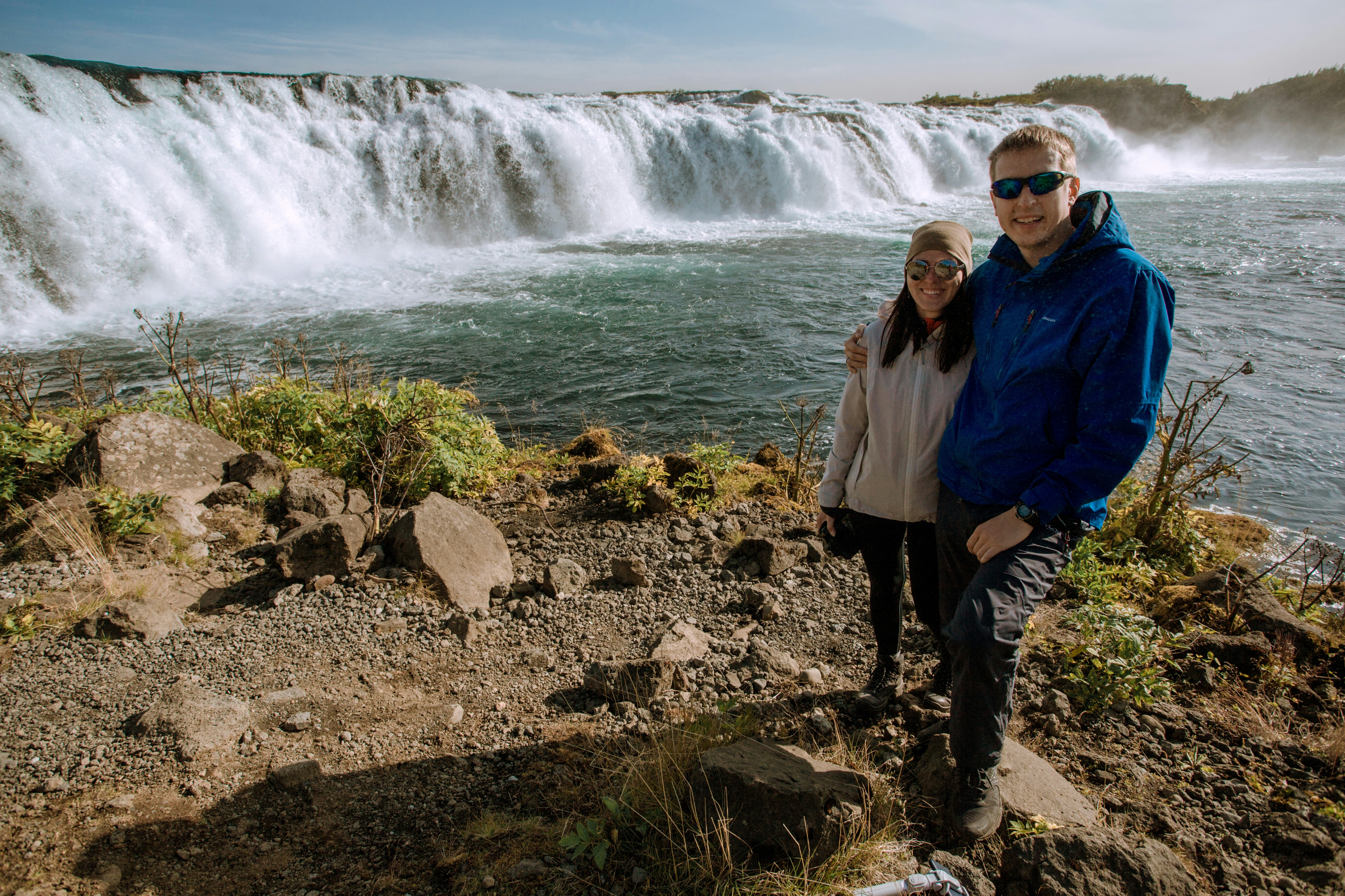Un homme et une femme posant pour une photo devant une cascade photo ...