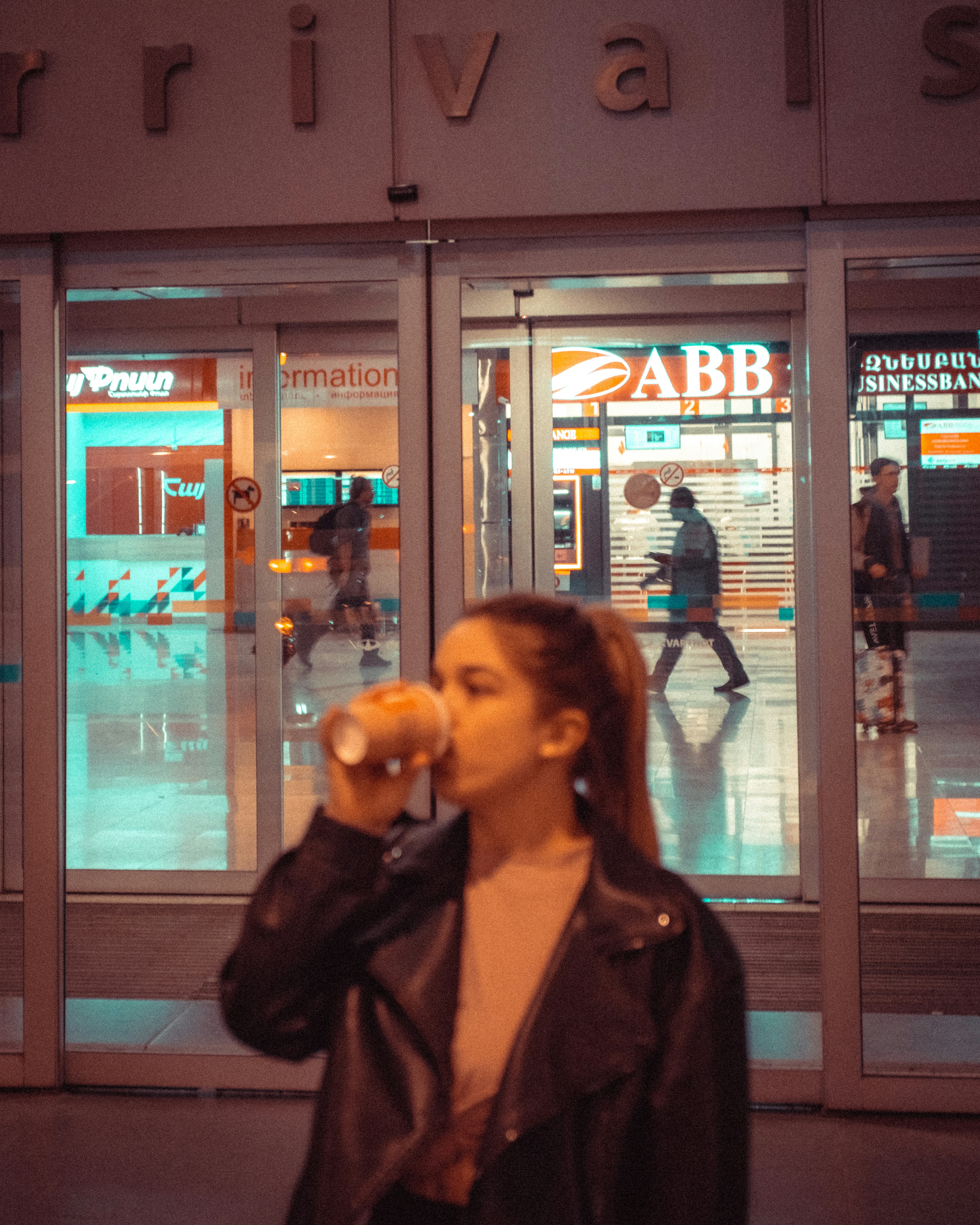 Cafe-city Pulse: A Young Woman in a Leather Jacket at an Urban Transit Hub