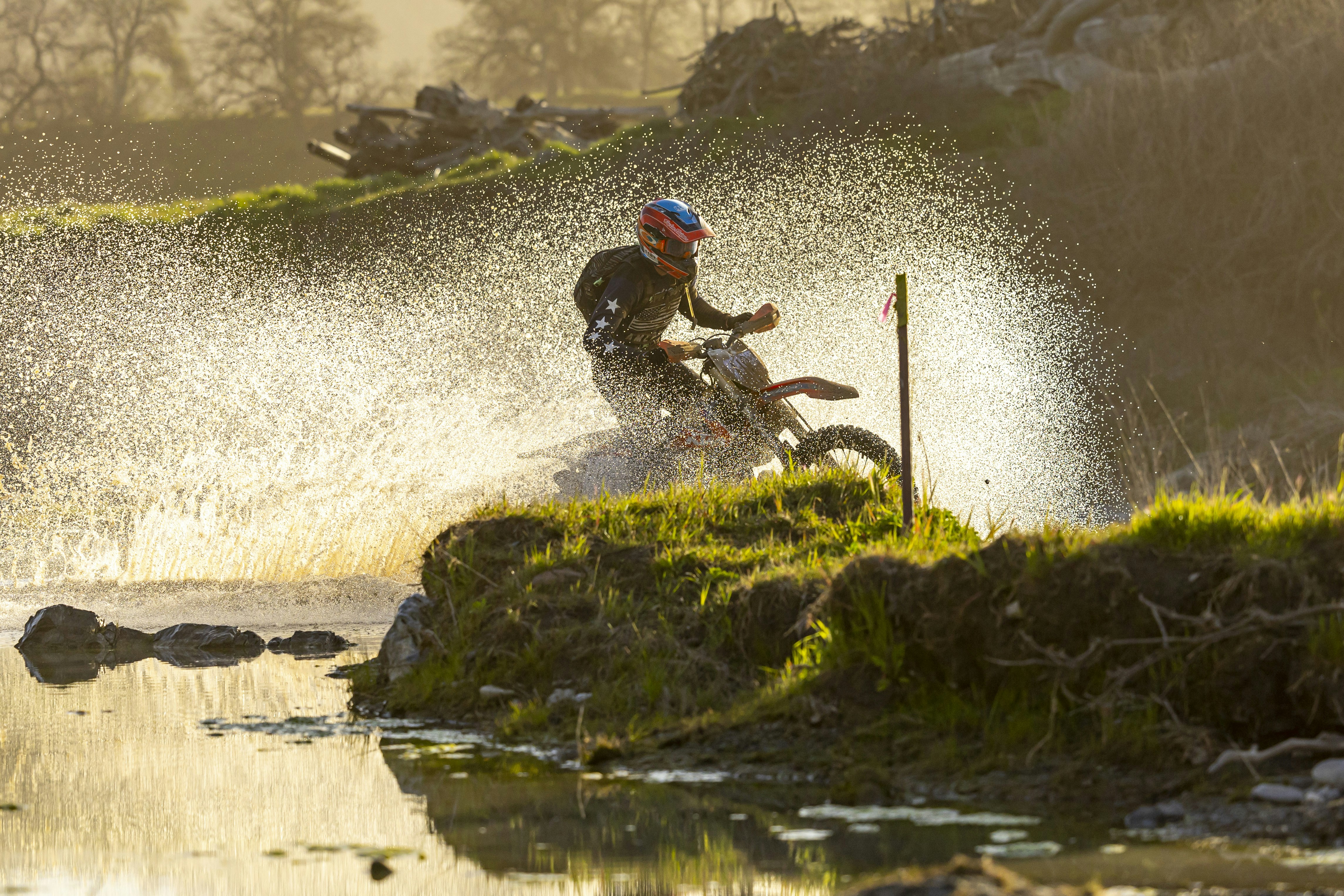 A man riding a bike on a dirt trail in a river photo – Free Motorcycle ...